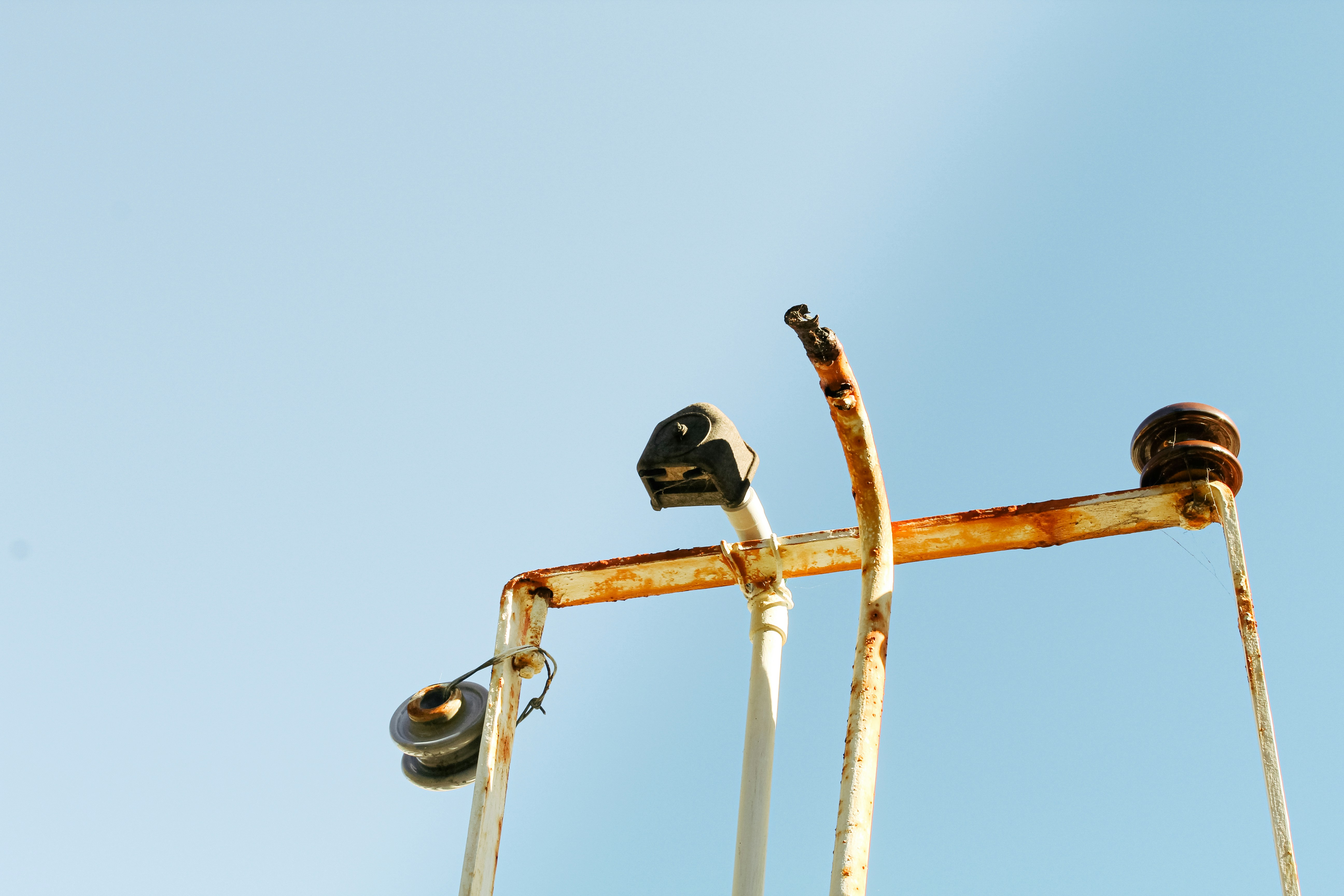 Weathered metal structures against a clear blue sky highlight the passage of time and neglect.