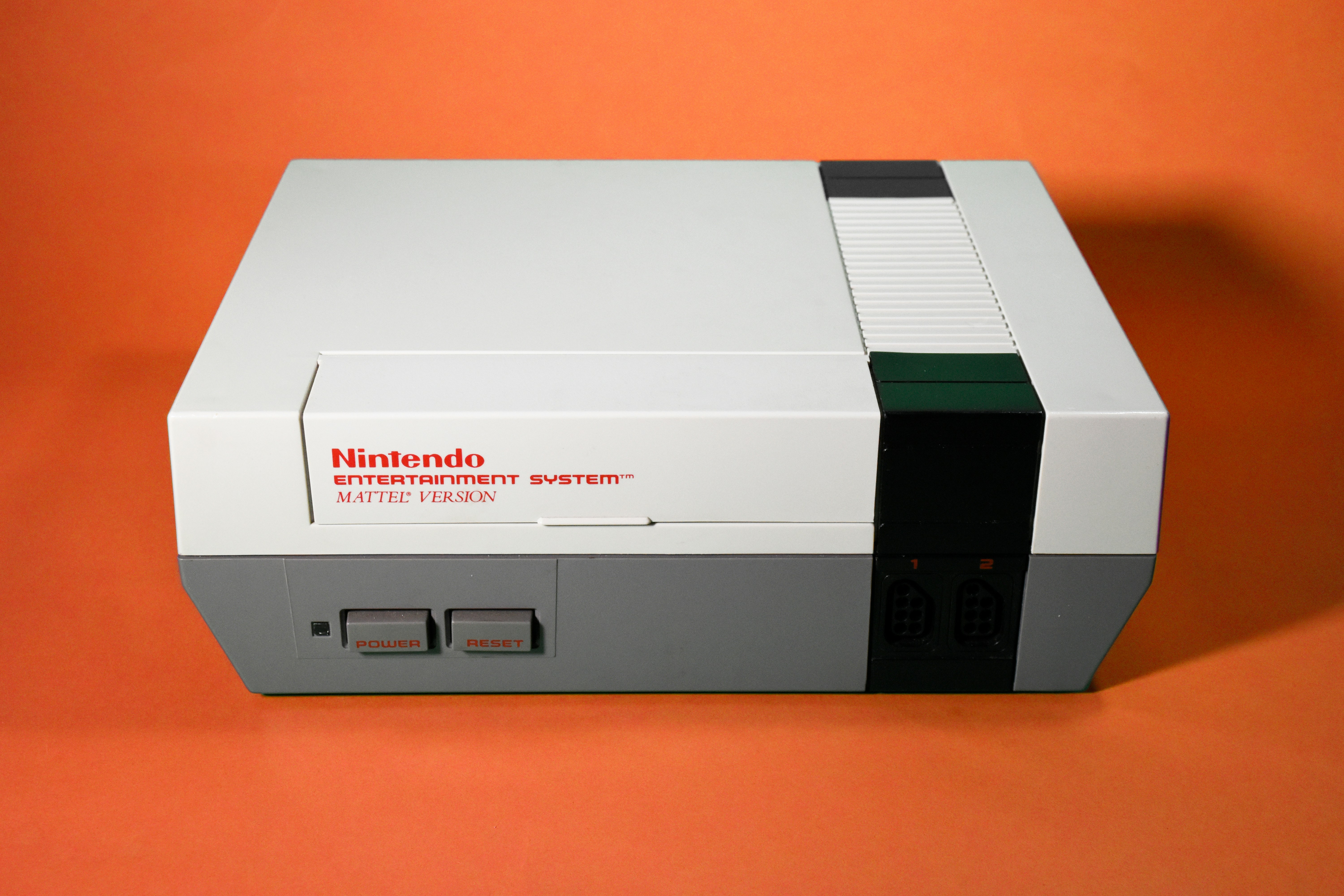 An old nintendo game console sitting on an orange surface photo – Free ...