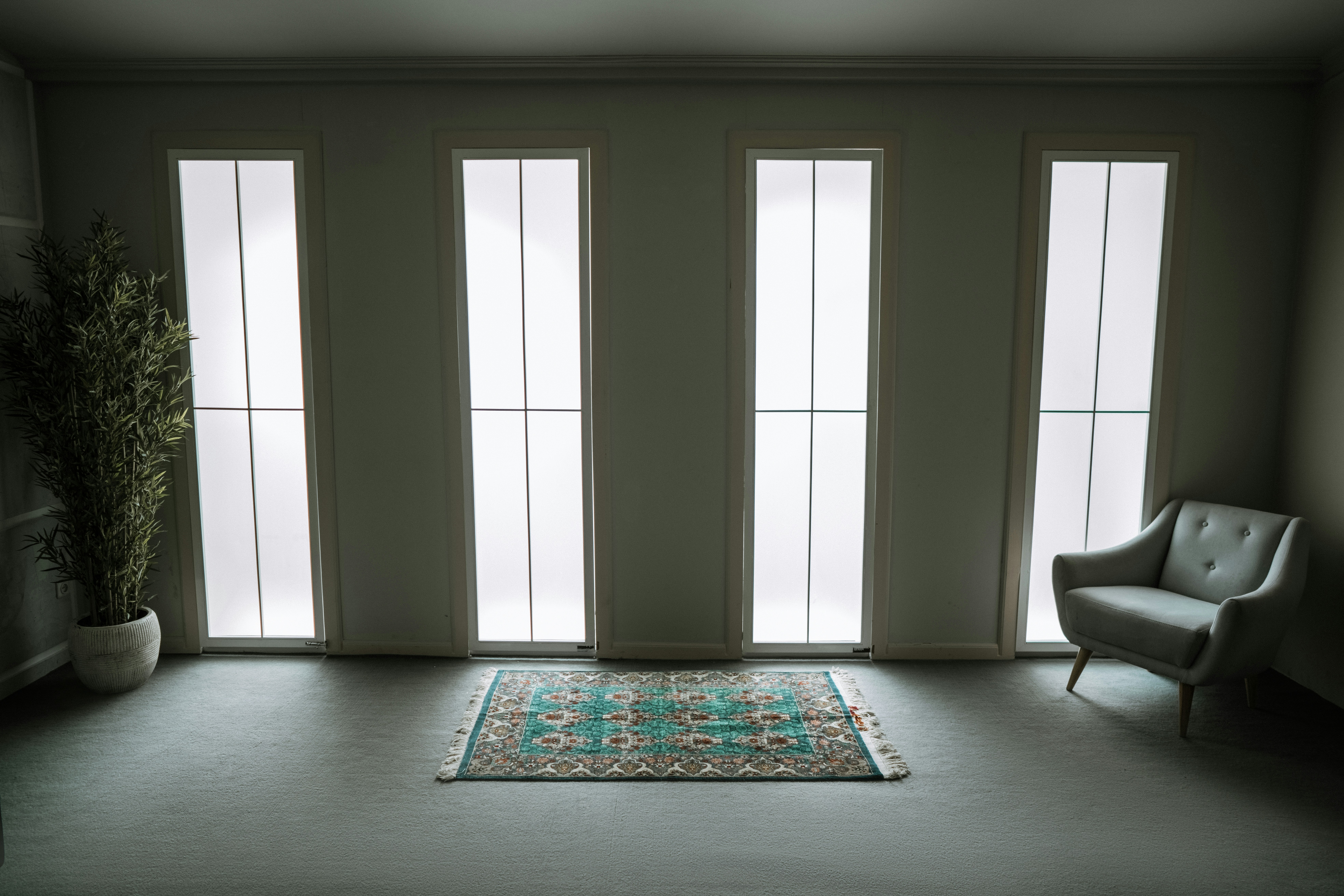 Quiet Light Through Four Tall Windows Over a Central Rug in a Minimalist Room