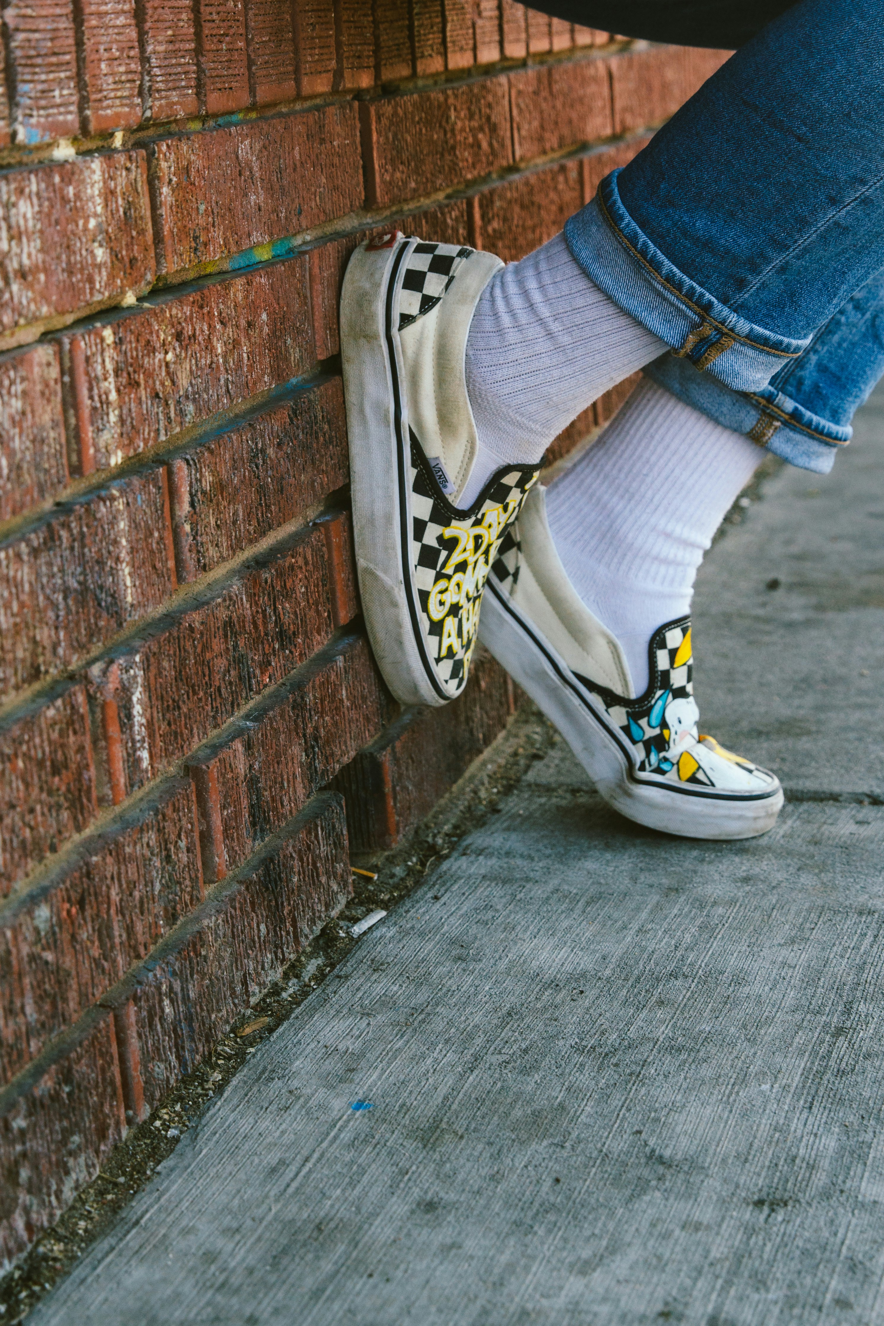 Checkerboard Reverie: Sneakers Rest Against a Brick Wall