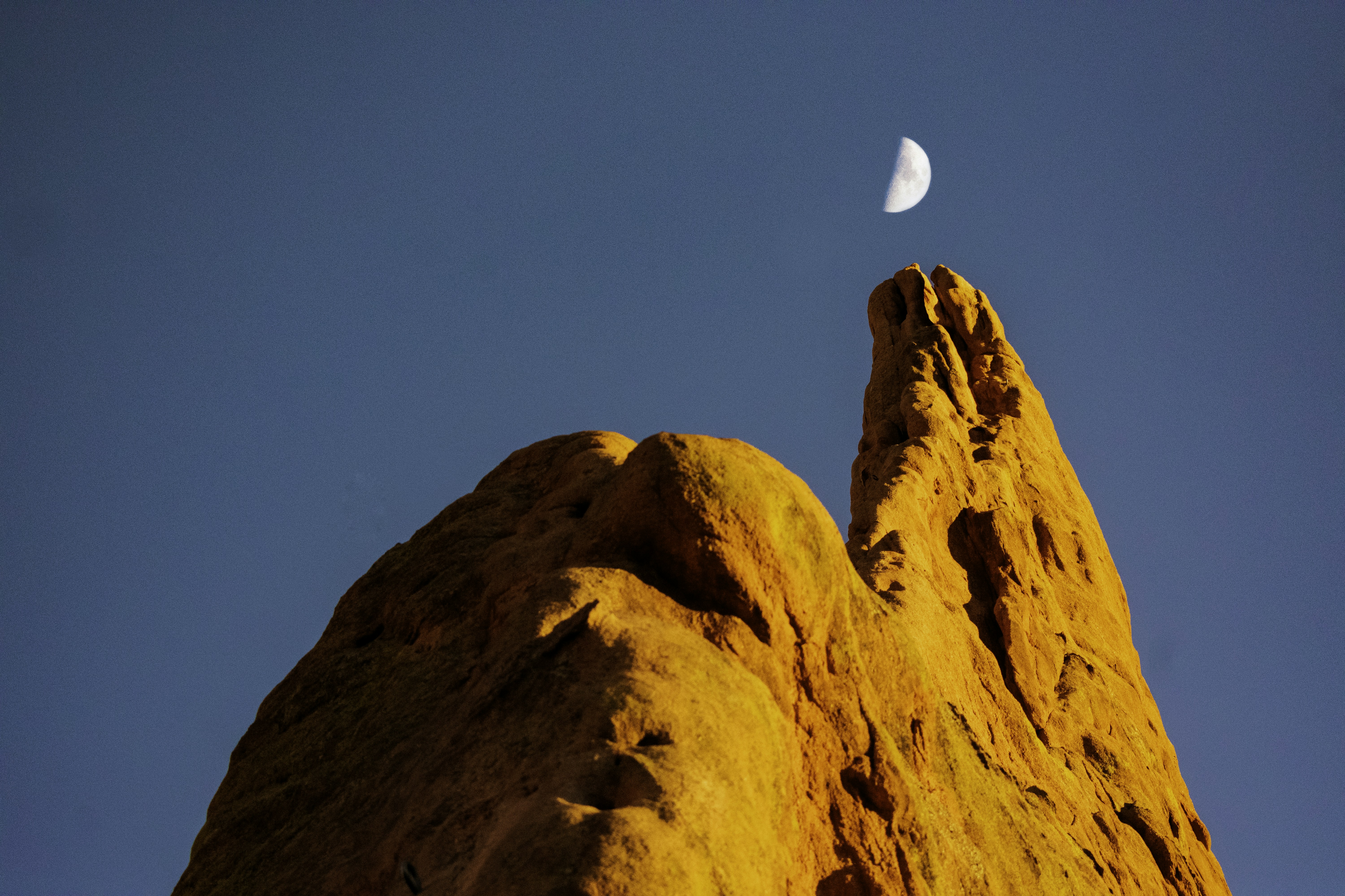Moonlit Crescent Over a Sun-Washed Granite Spire