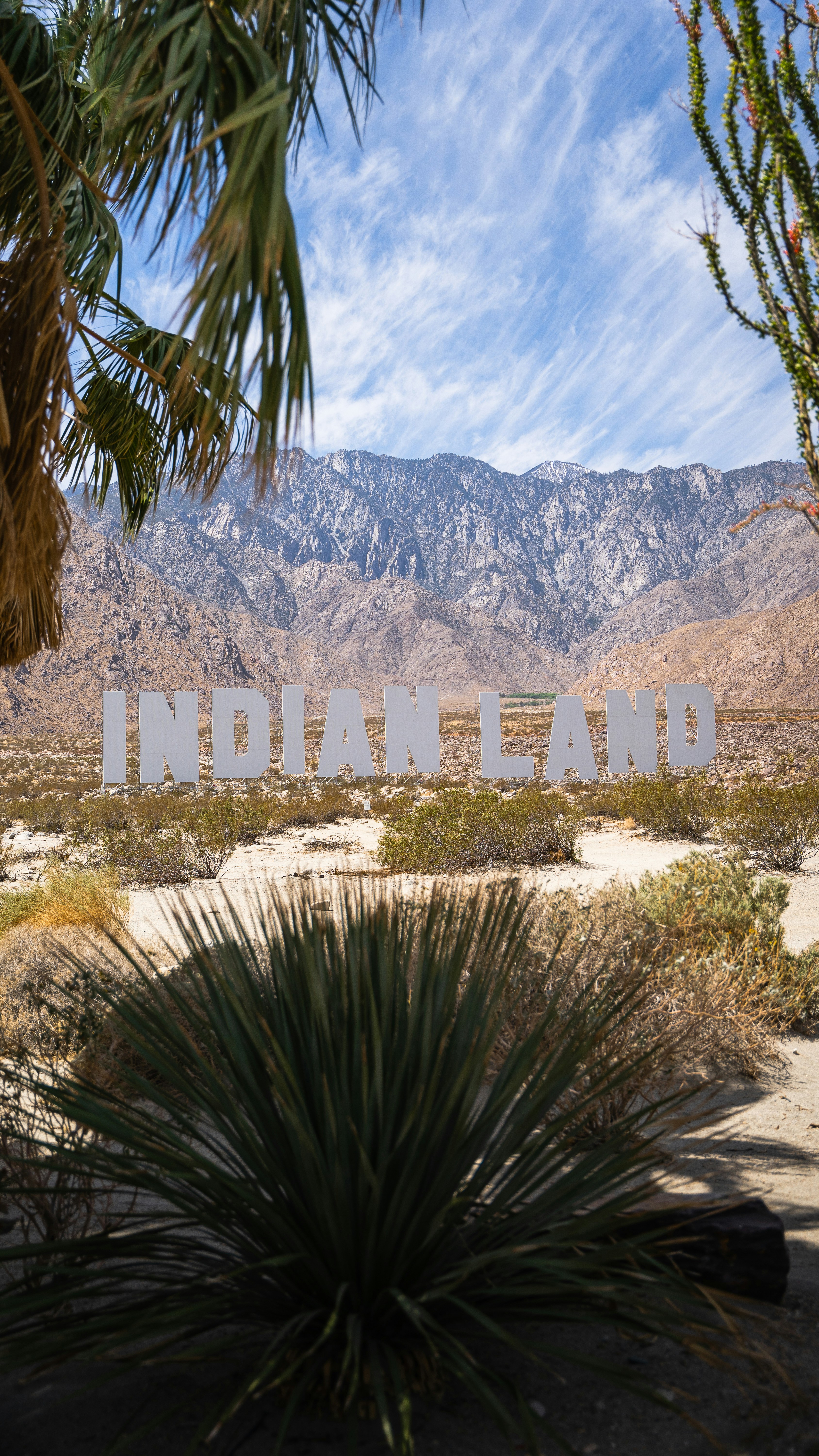 INDIAN LAND Sign Framed by Desert Scrub and a Range of Distant Peaks