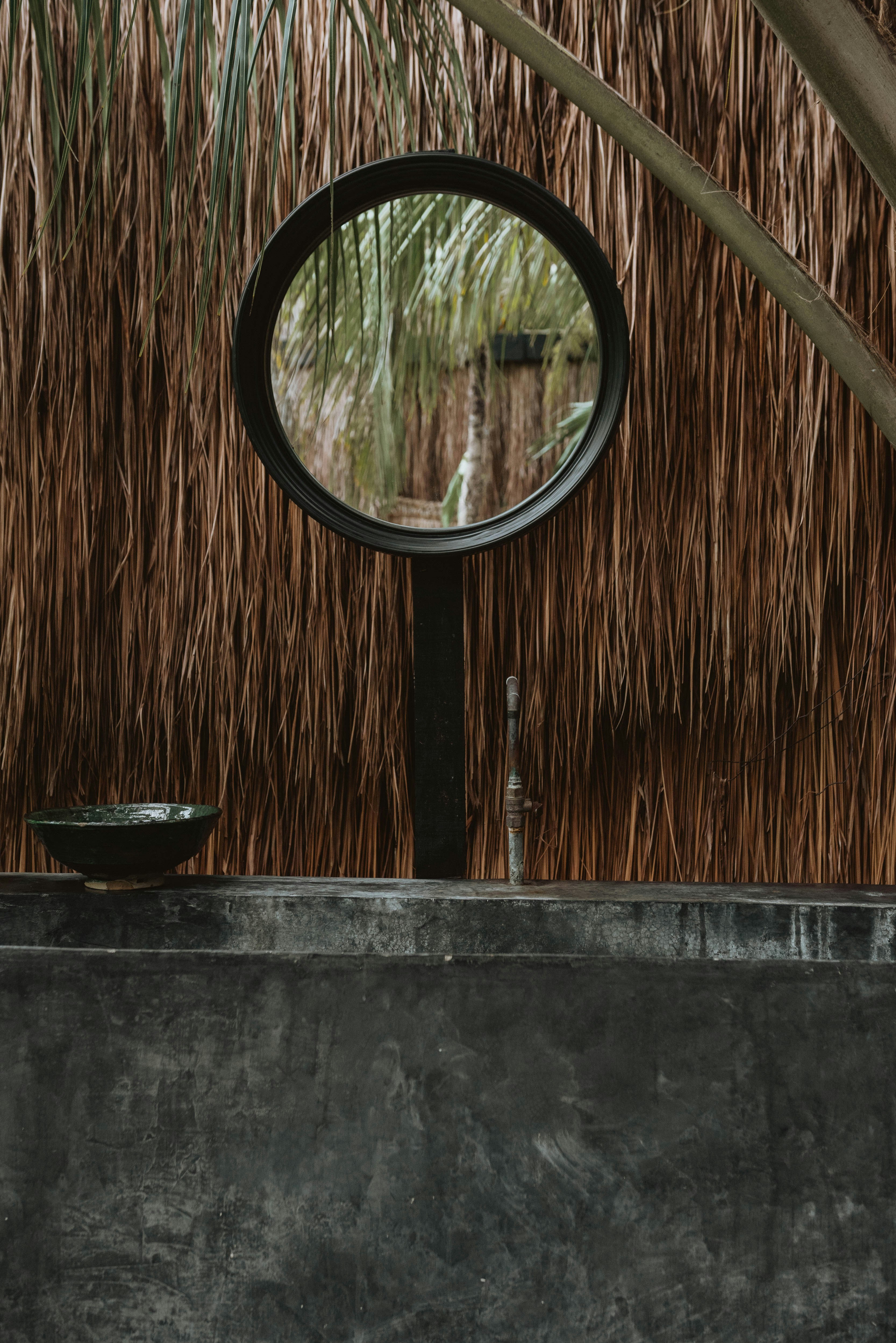 Round Mirror Framed by Rustic Weave: A Minimalist Still Life
