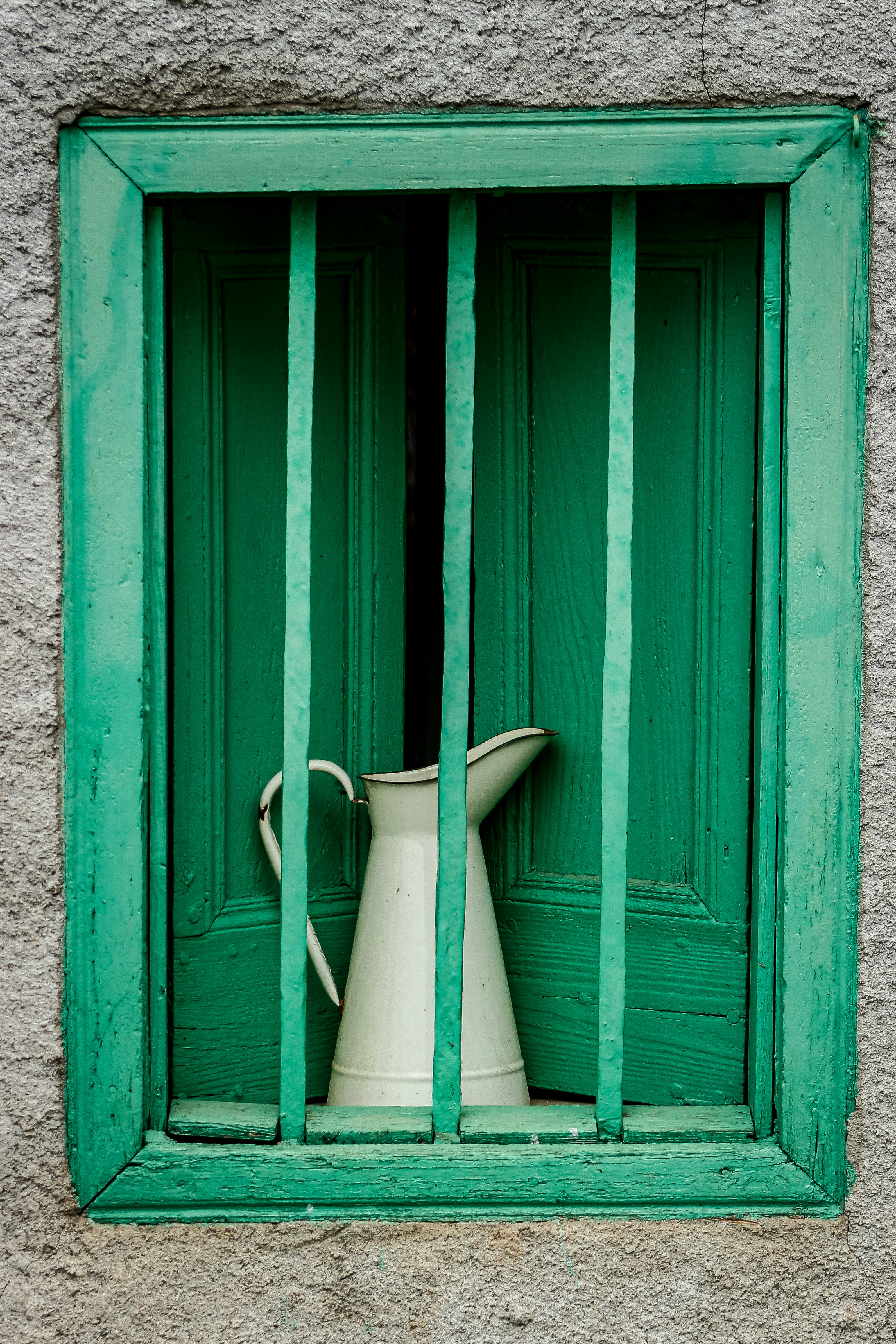 White Pitcher Behind Green Bars