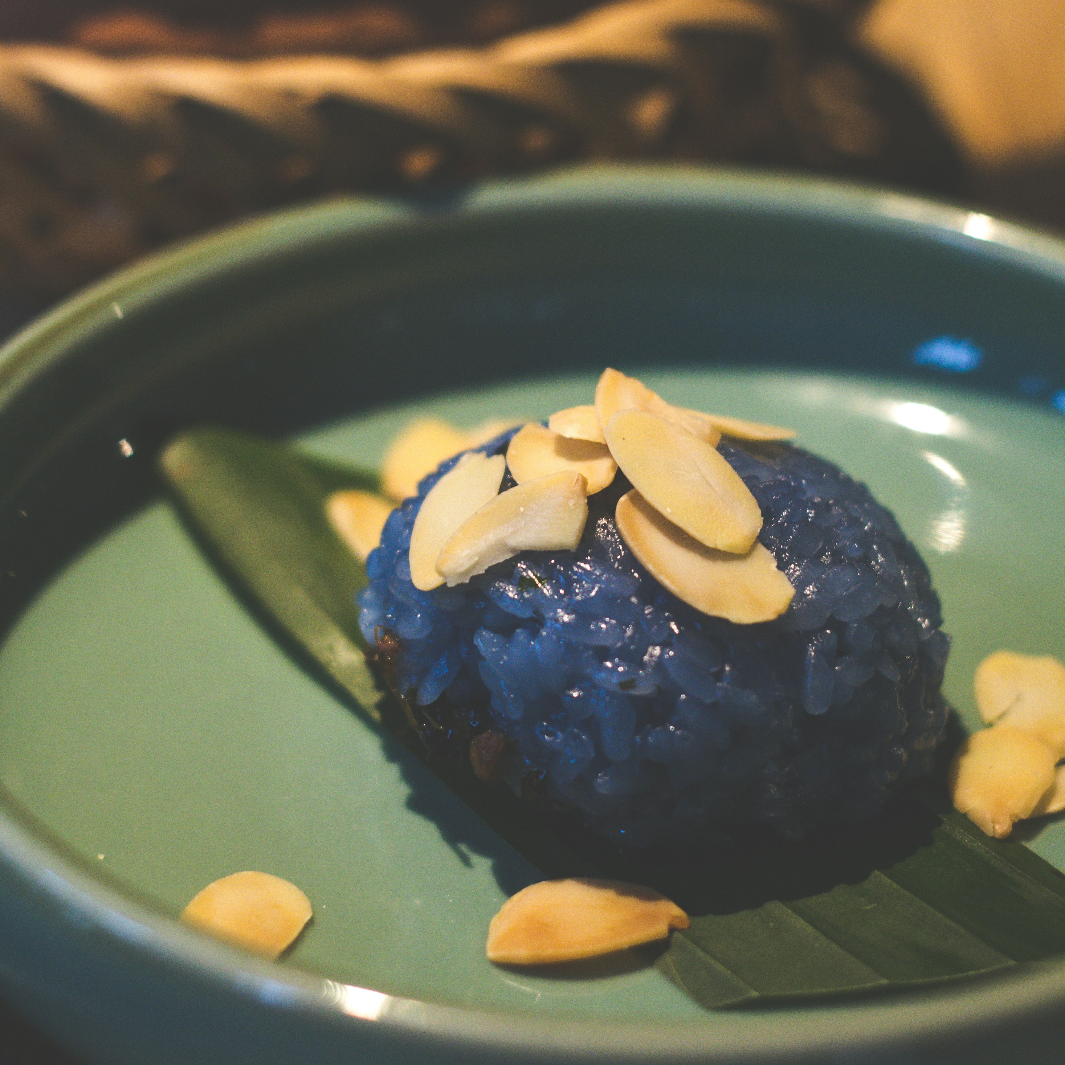 Indigo Glutinous Rice Ball Crowned with Almond Slices on a Green Banana-Leaf Plate
