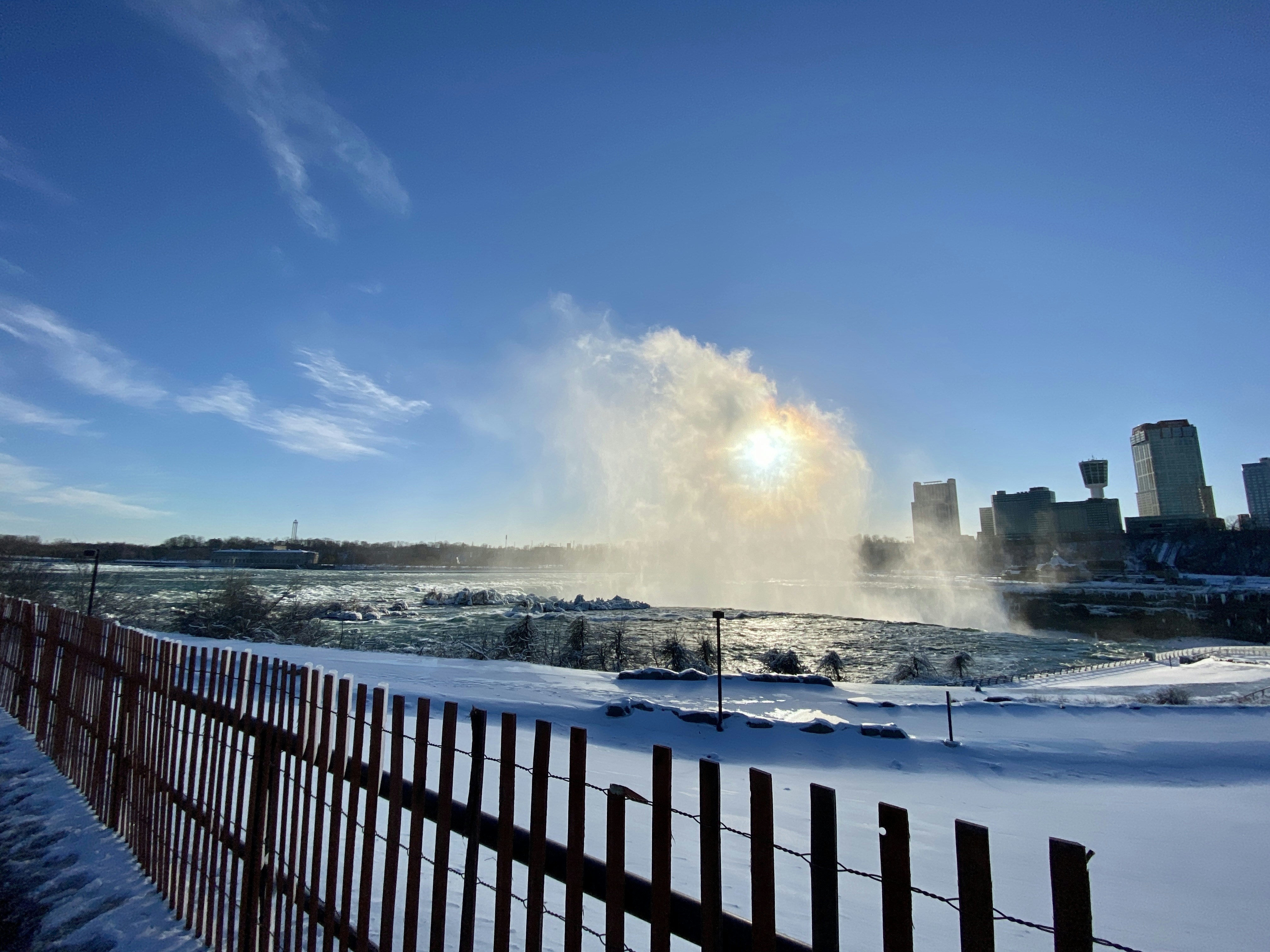 Frozen Spray over a Snowbound Riverfront with City Silhouette