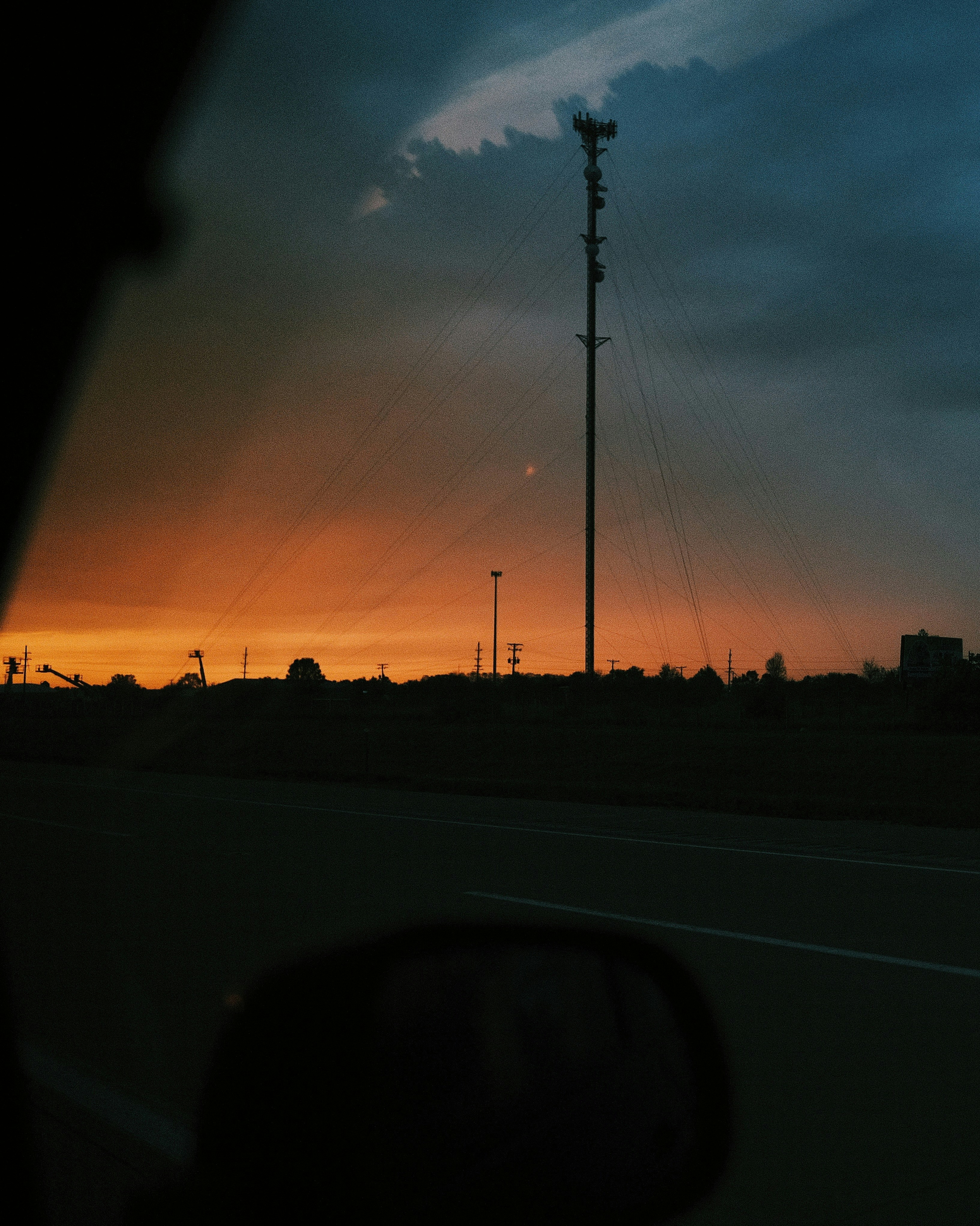 Tall Sentinel at Sunset: An Empty Highway Silhouette Under a Two-Tone Sky