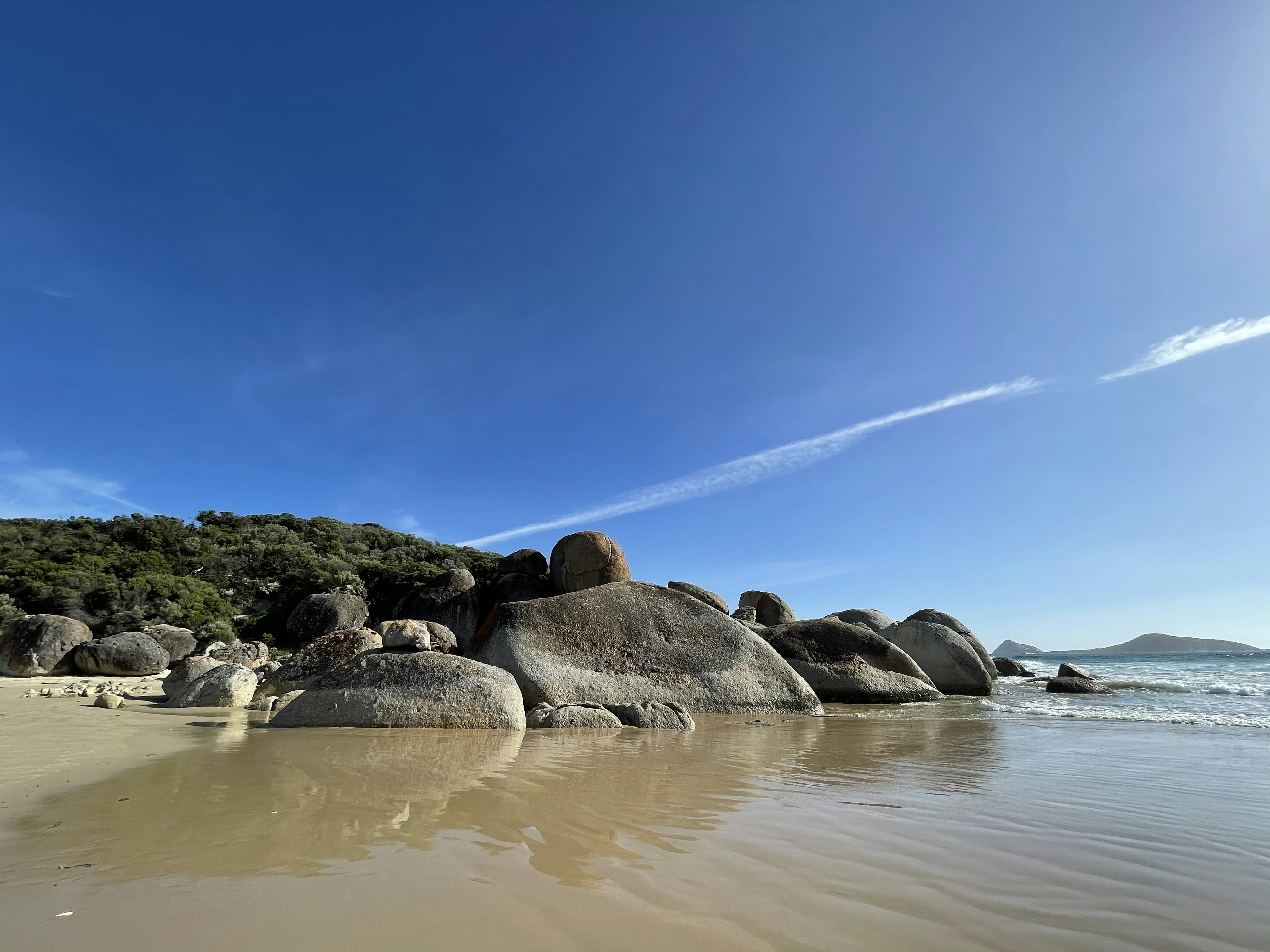 rocks on water under blue sky during daytime