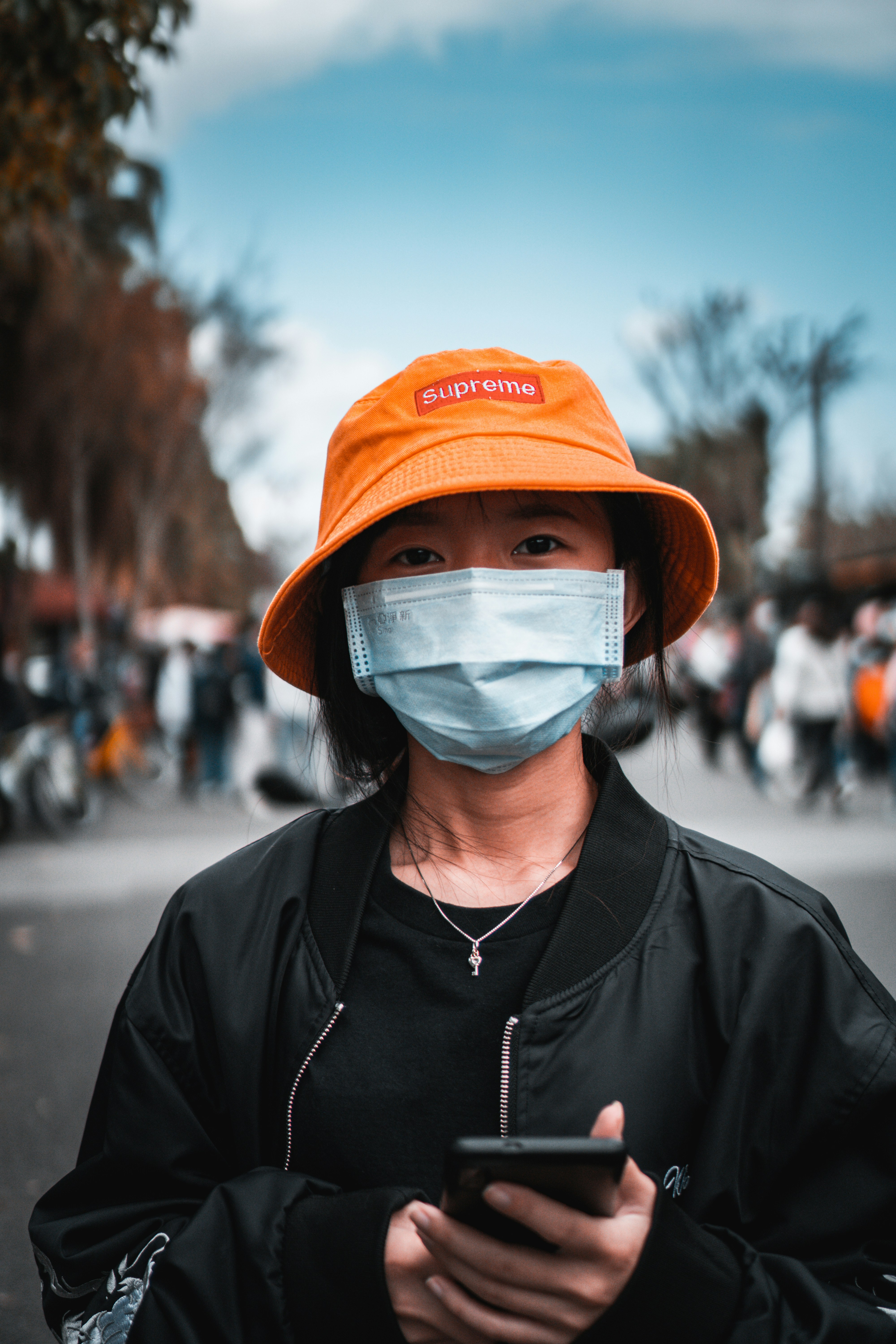 Masked Moment Under the Orange Supreme Hat in a Crowded Street Portrait