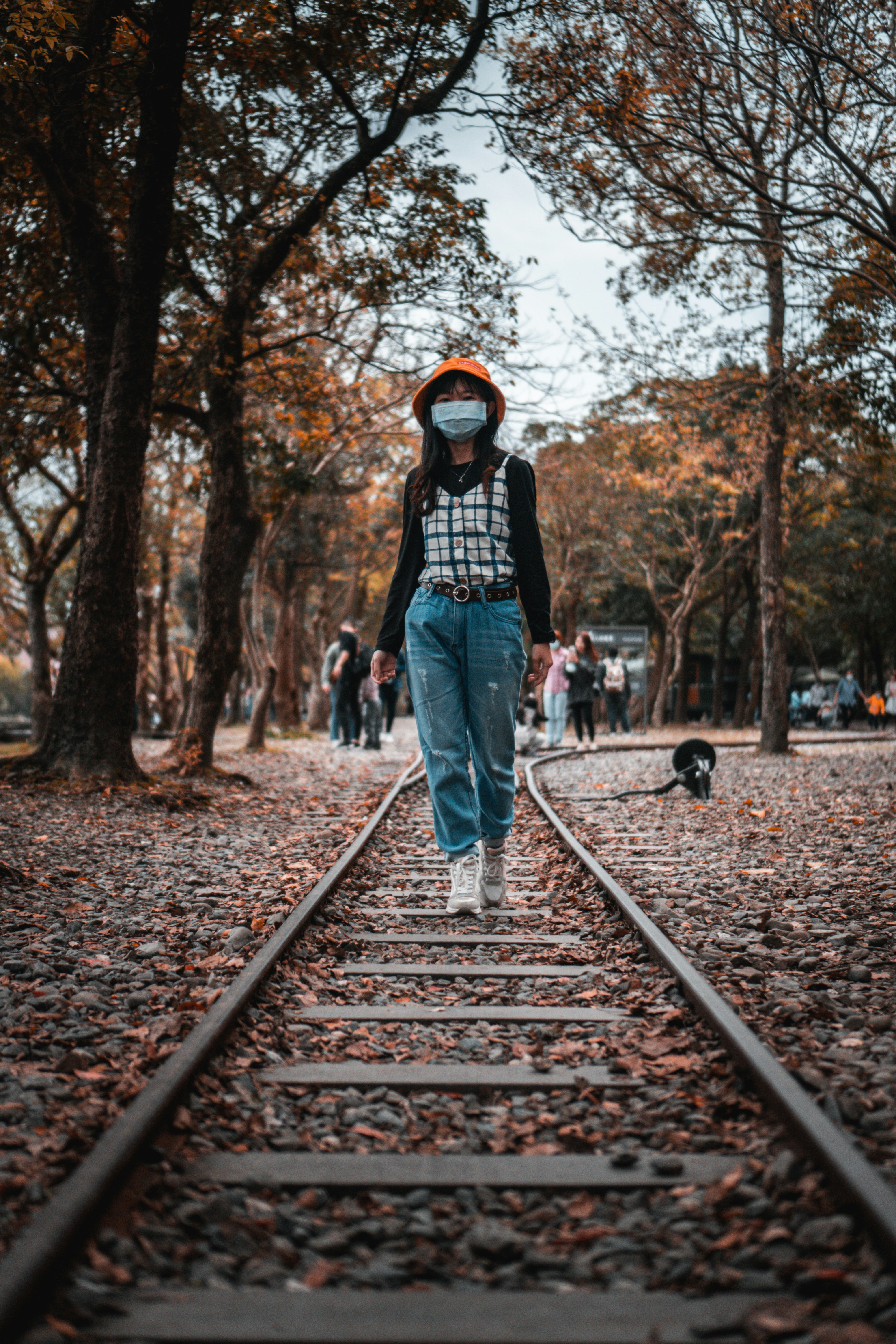 Masked Saunter: A Quiet Figure on Weathered Rails