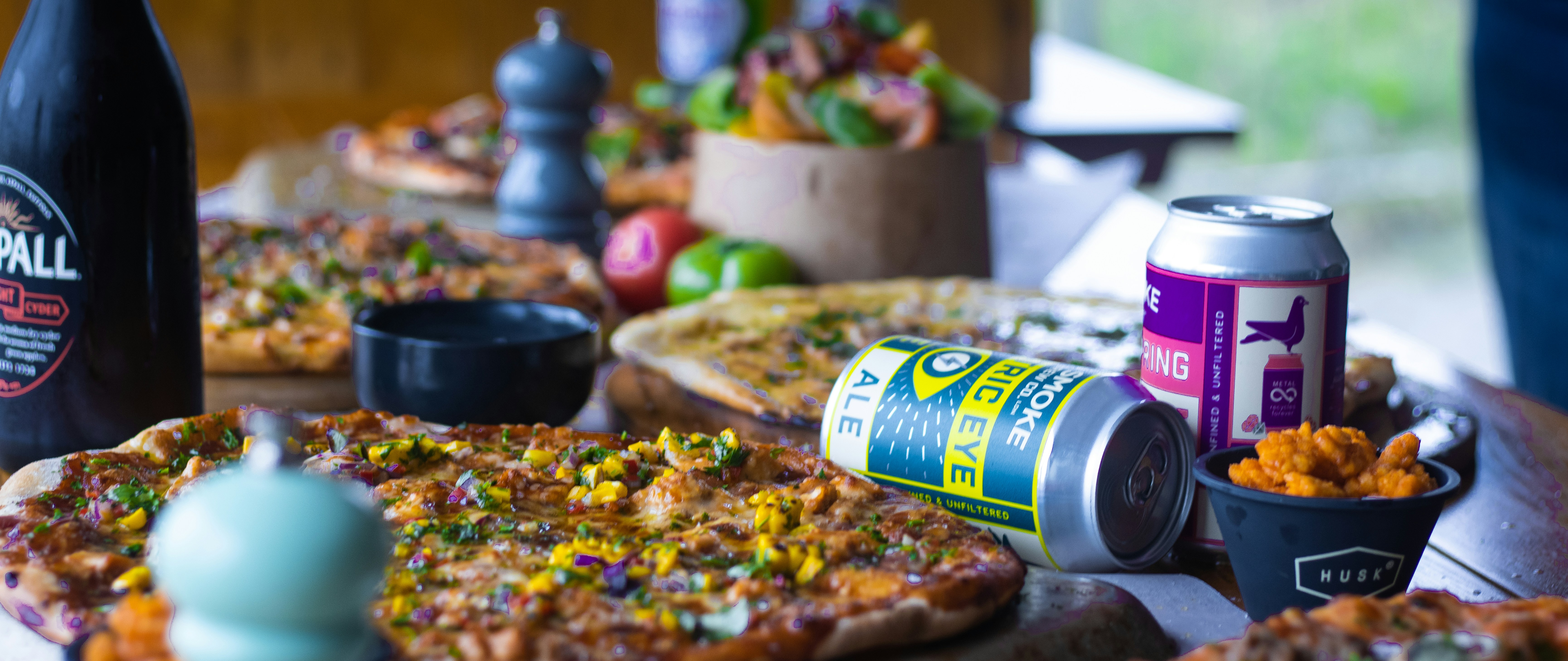 Pepperoni Parade on a Rustic Table: Pizza, Cans, and Crunchy Sides