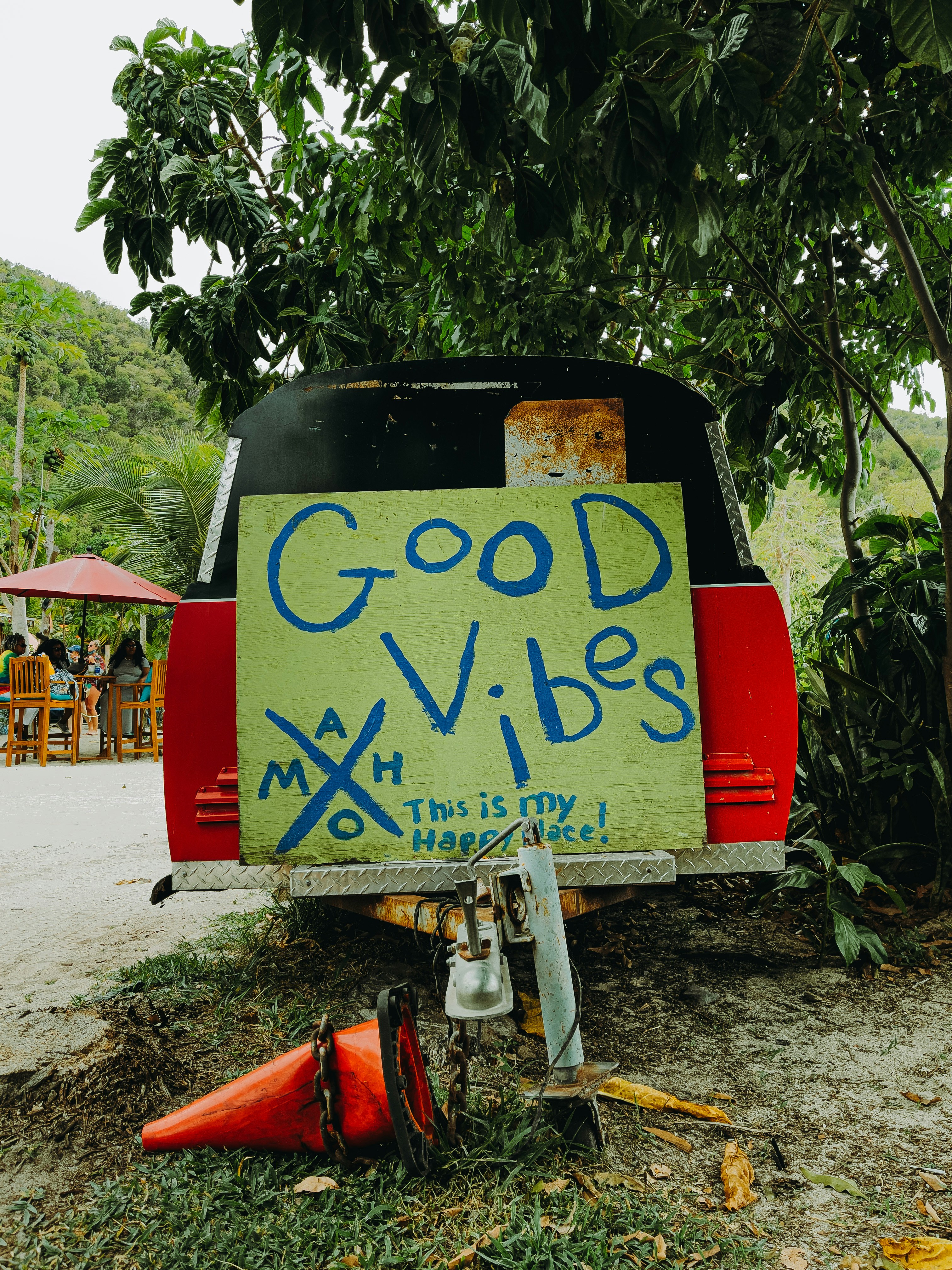 Good Vibes on Wheels: a hand-painted sign brightens a sunlit roadside scene