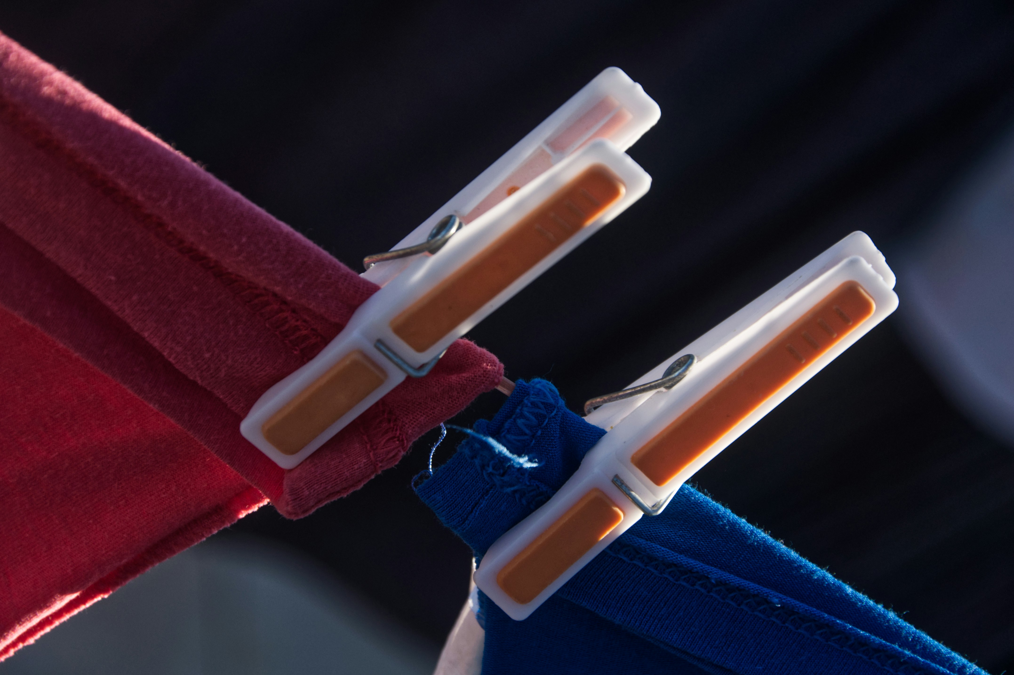 Bright Clothespins Stand Out Against Dark Laundry Line