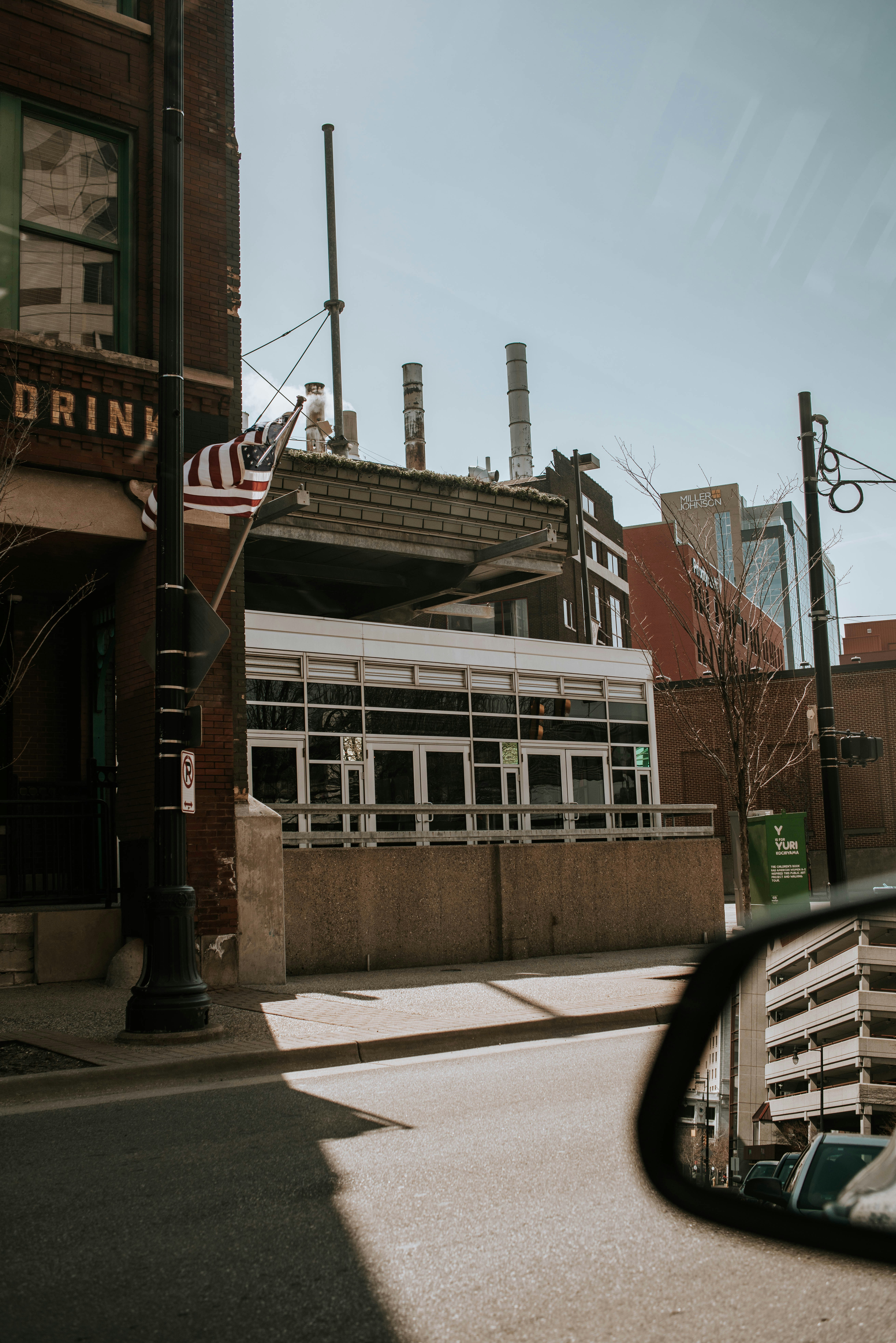 Construction site juxtaposed with urban architecture, featuring a partially completed building and an American flag. A city street scene captures the essence of urban development.
