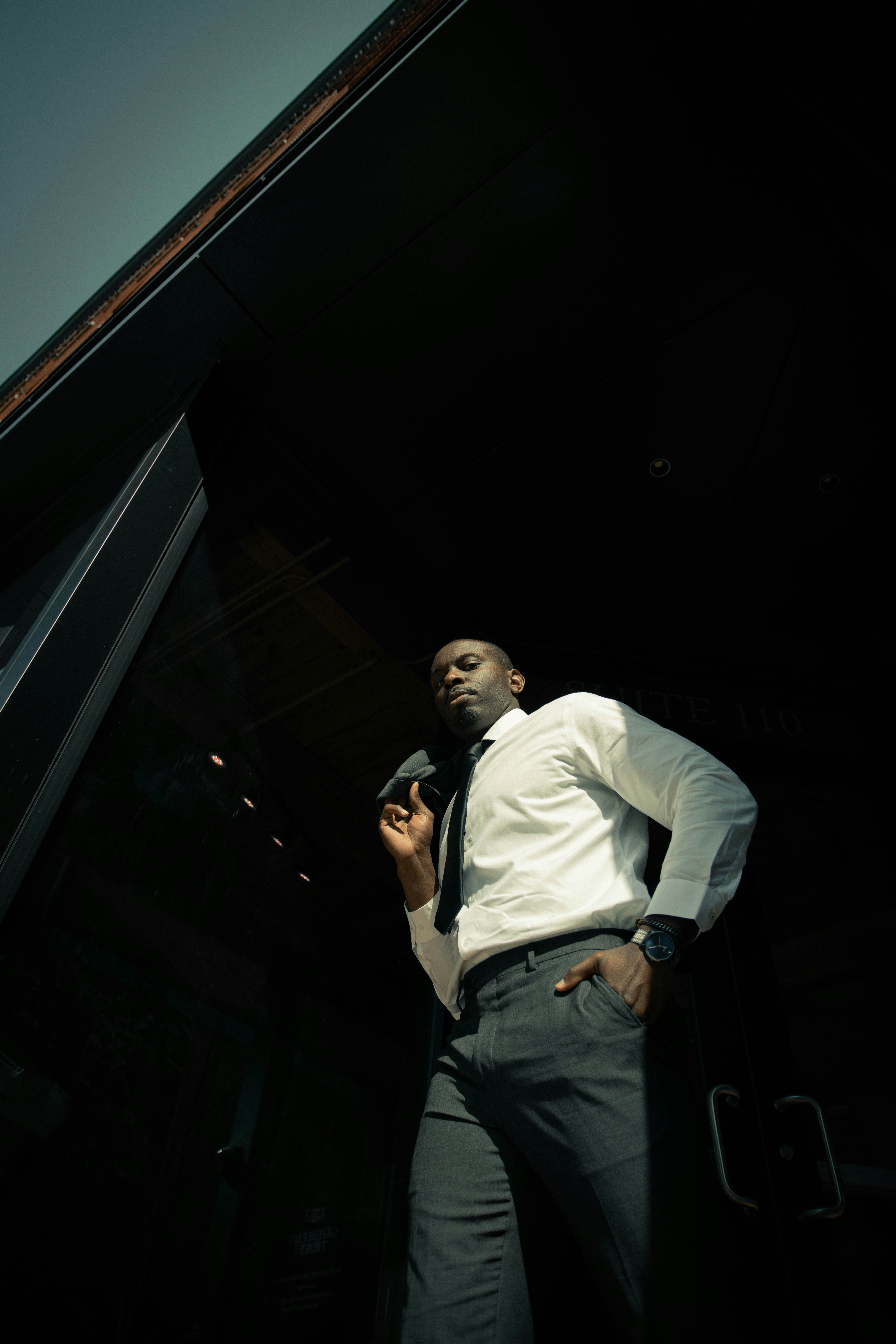 Threshold of Resolve: A Low-Angle Portrait in a Glass-Walled Entrance