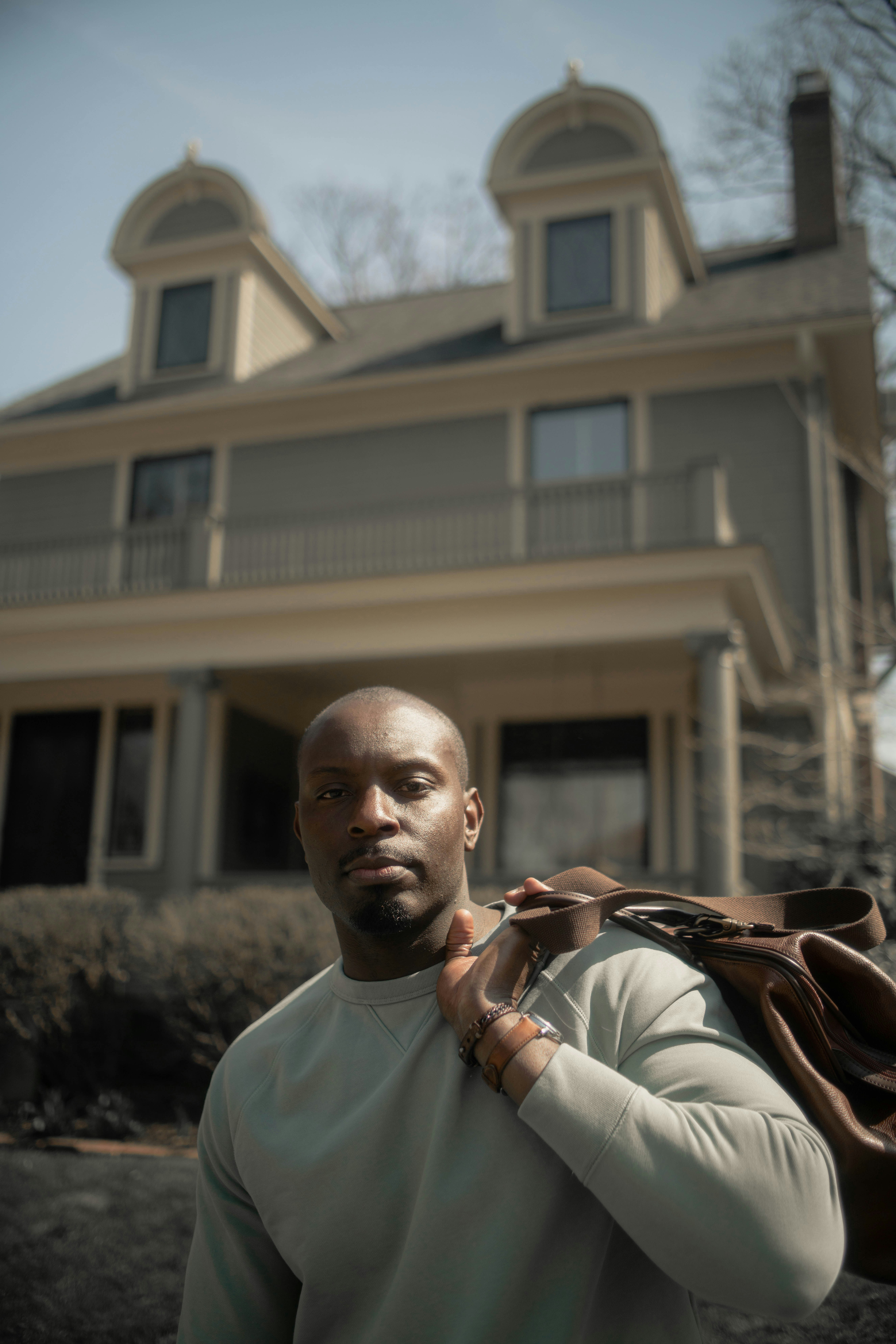 Leather Messenger, Grand Porch: A Quiet Street Portrait in Front of a Historic House