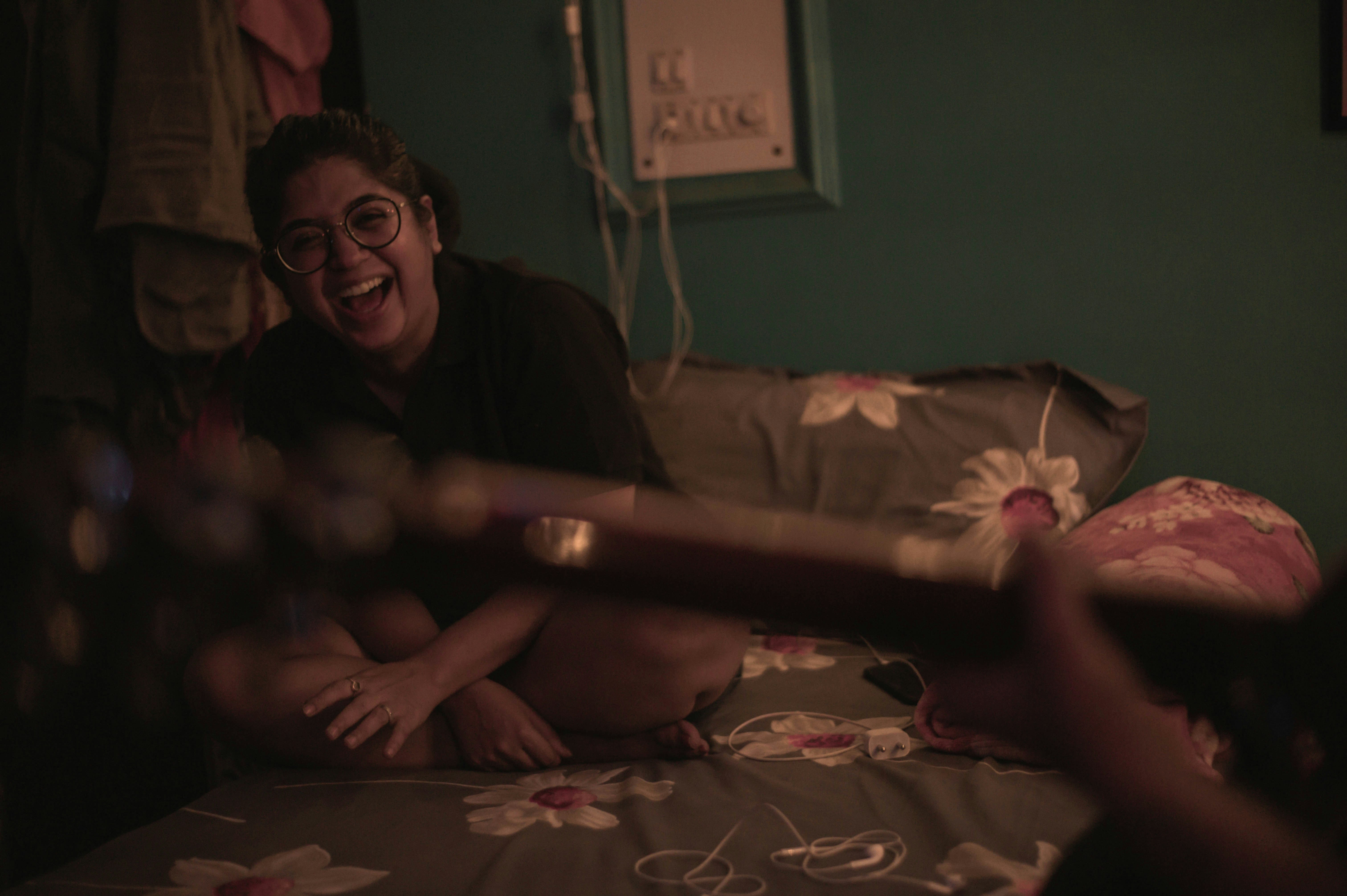 Candid Smile in a Dimly Lit Bedroom Studio