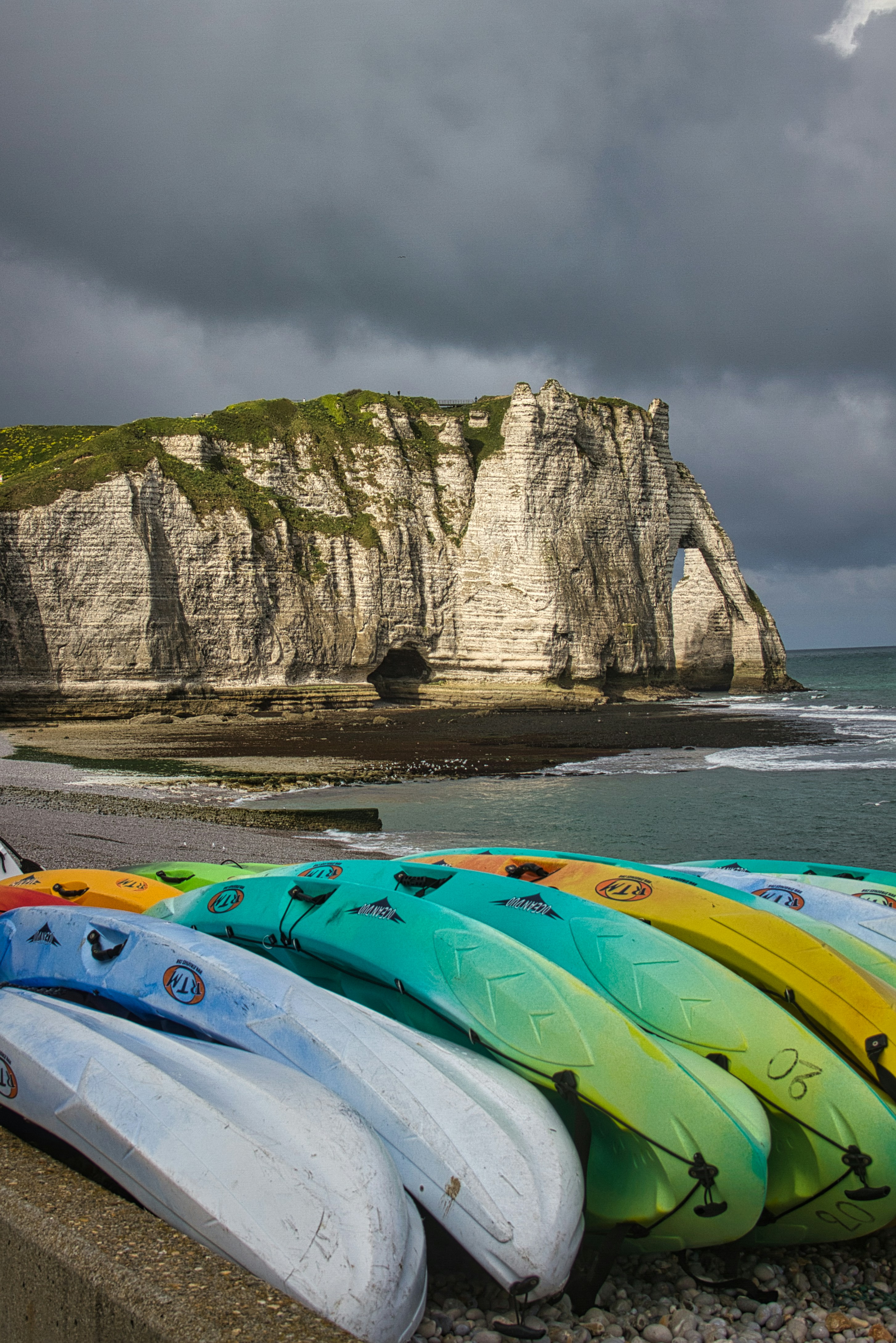 Colorful Kayaks at the Foot of a Chalk Cliff Arch