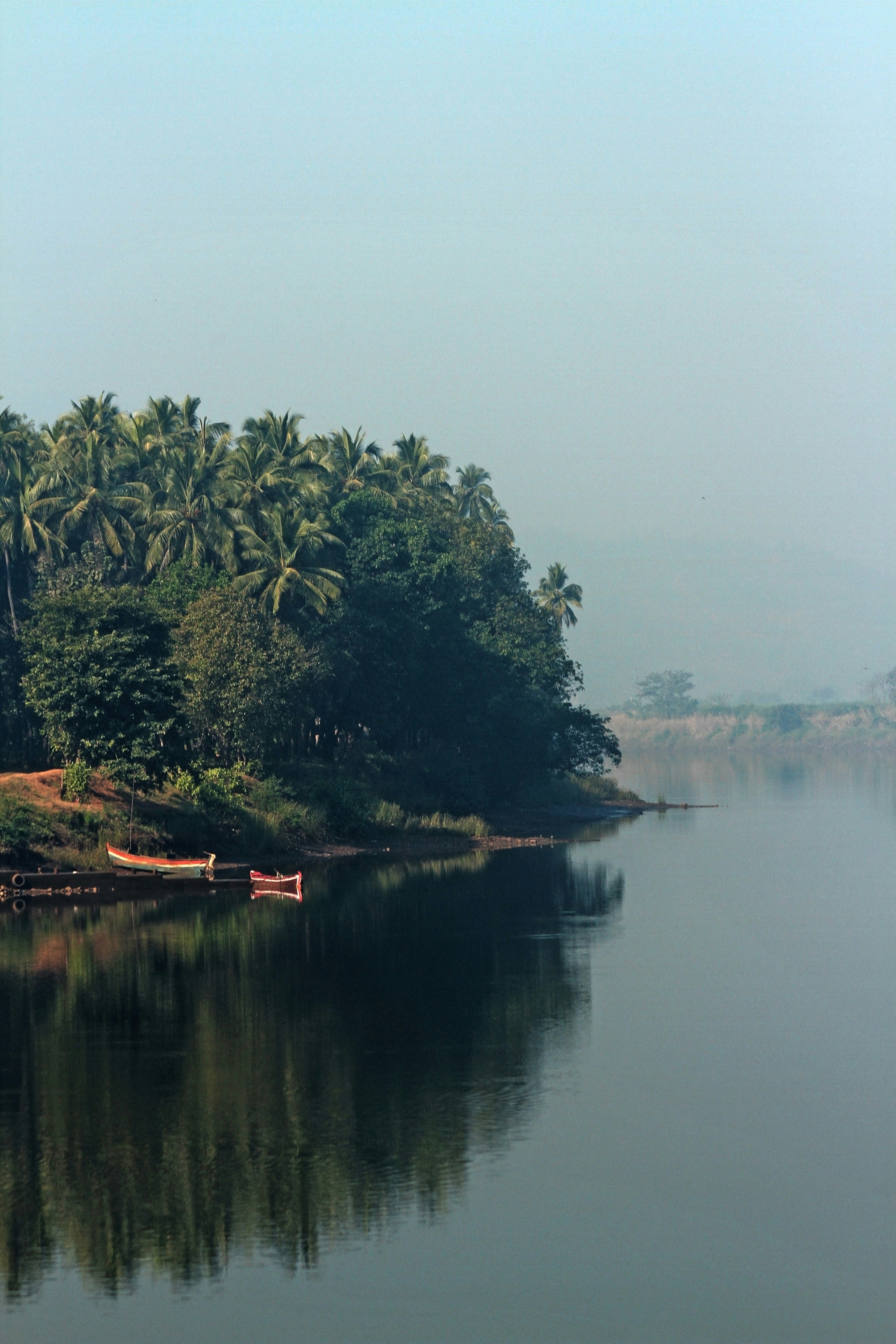 Boats docked on the bank of Savitri River in Mahad, Maharashtra, India.