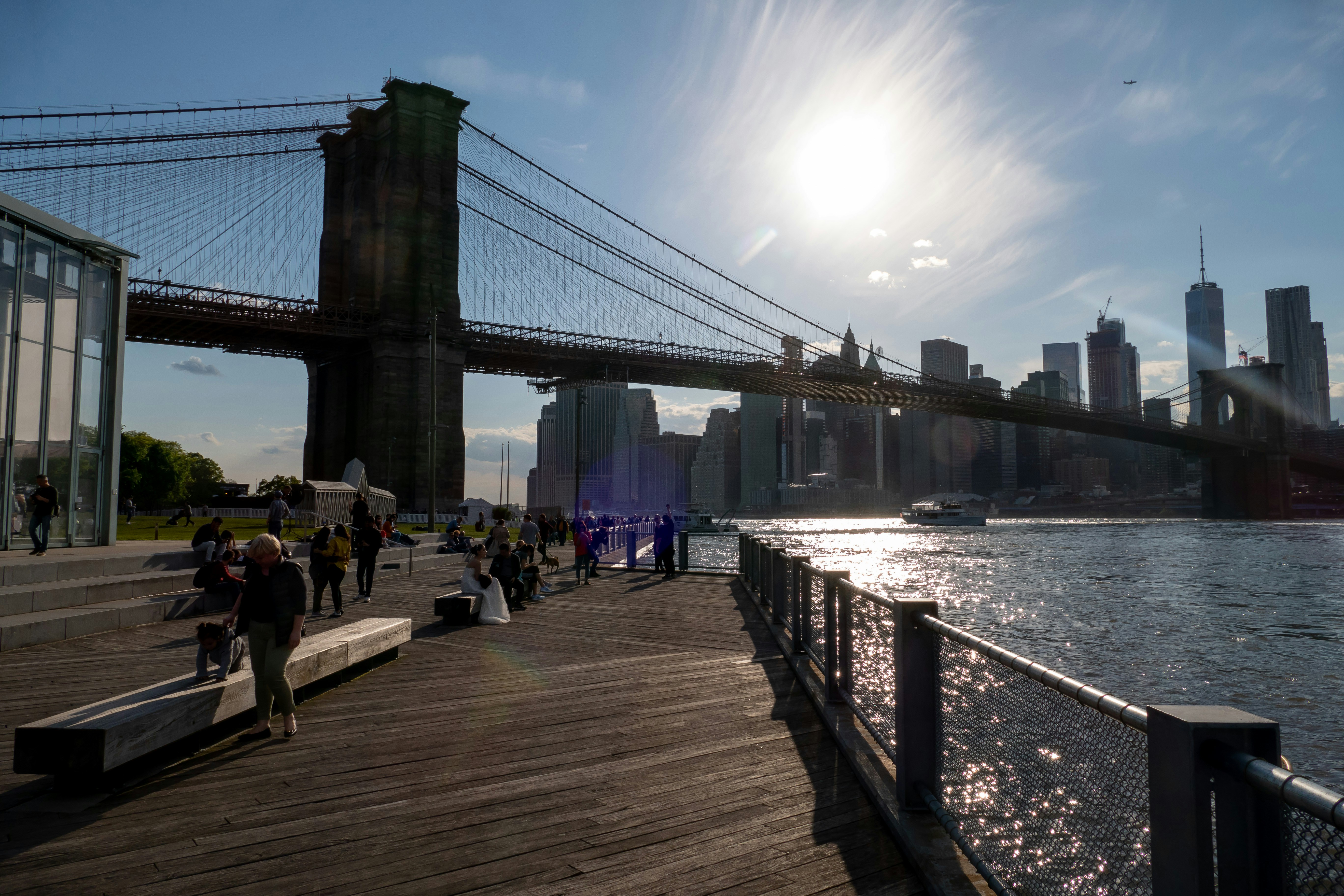 Sunlit Brooklyn Bridge Promenade Amid City Silhouette