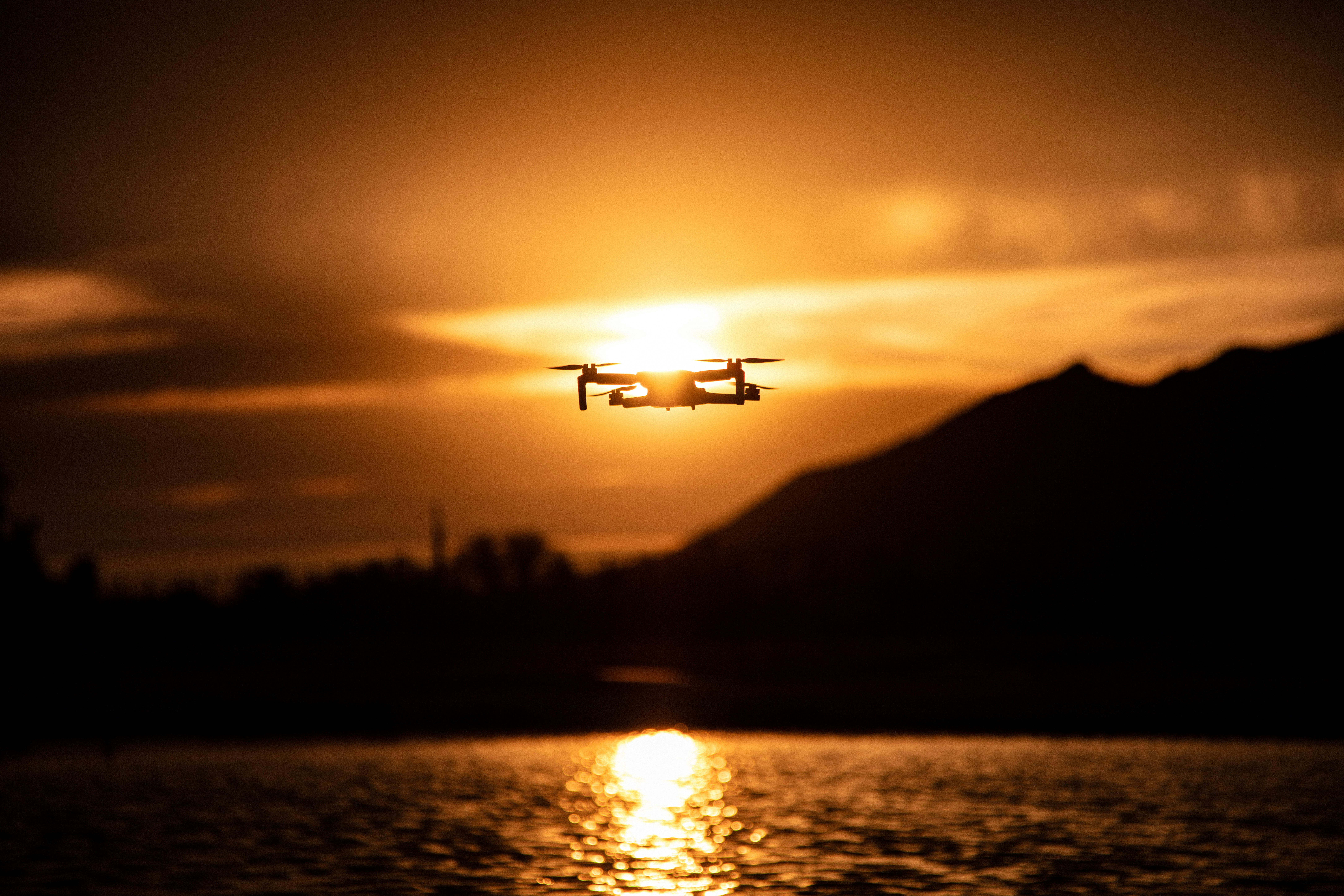Copper Horizon: Drone Hover Above a Sunset Silhouette