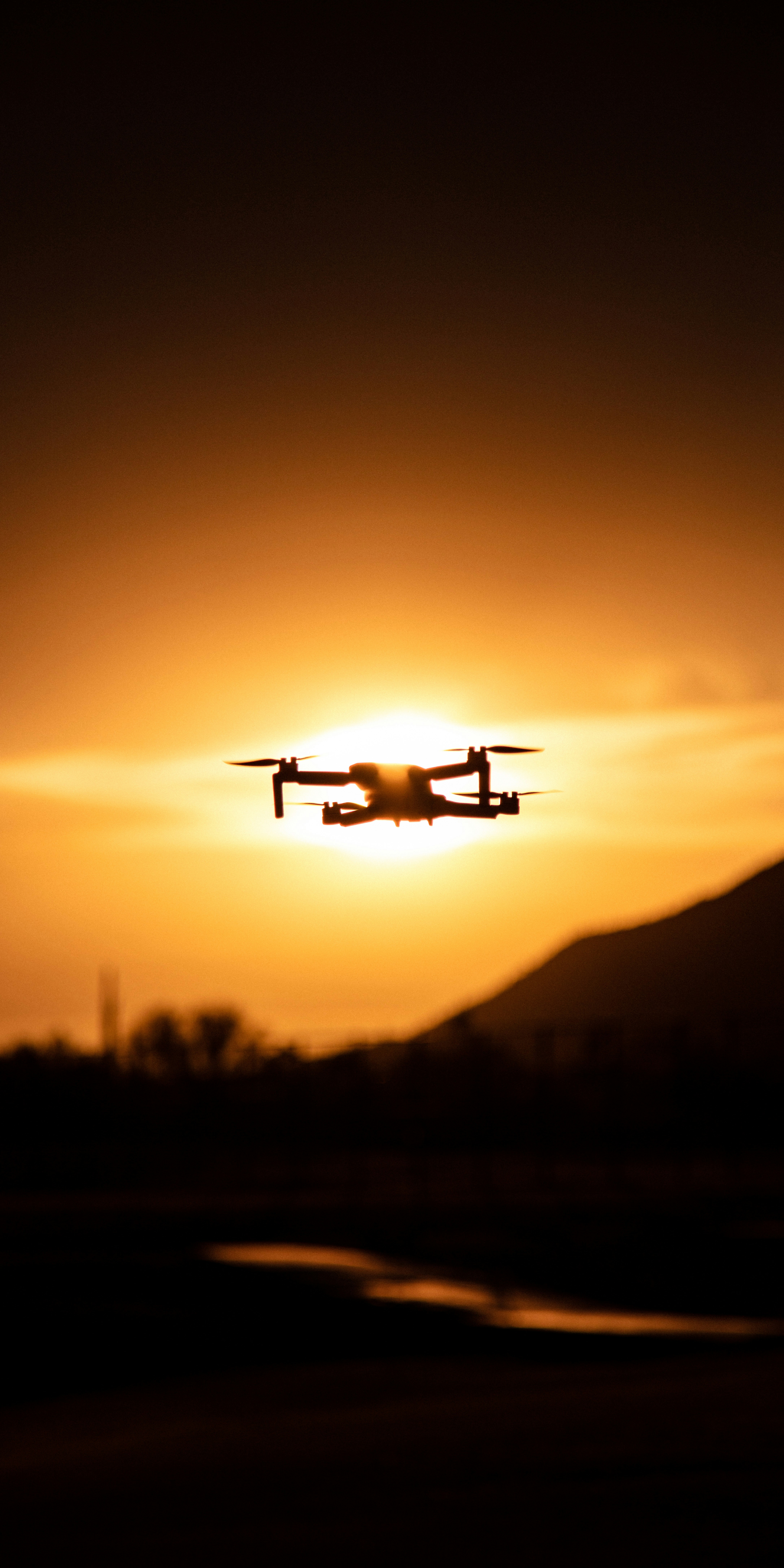 Golden Hour Hover: A Drone Silhouette Crossing the Sunset Horizon