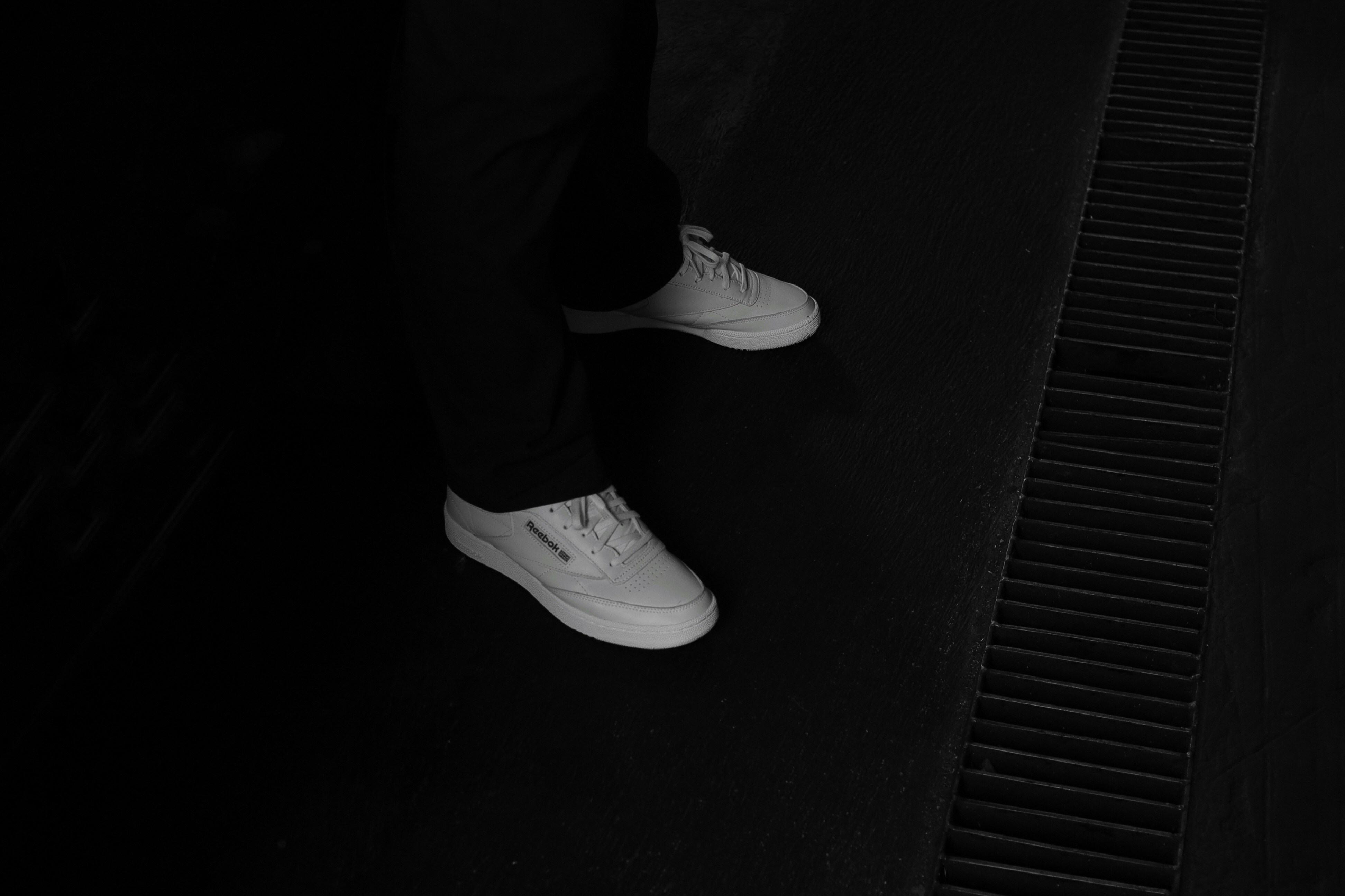 Midnight Footfall: White Sneakers on a Shadowed Threshold