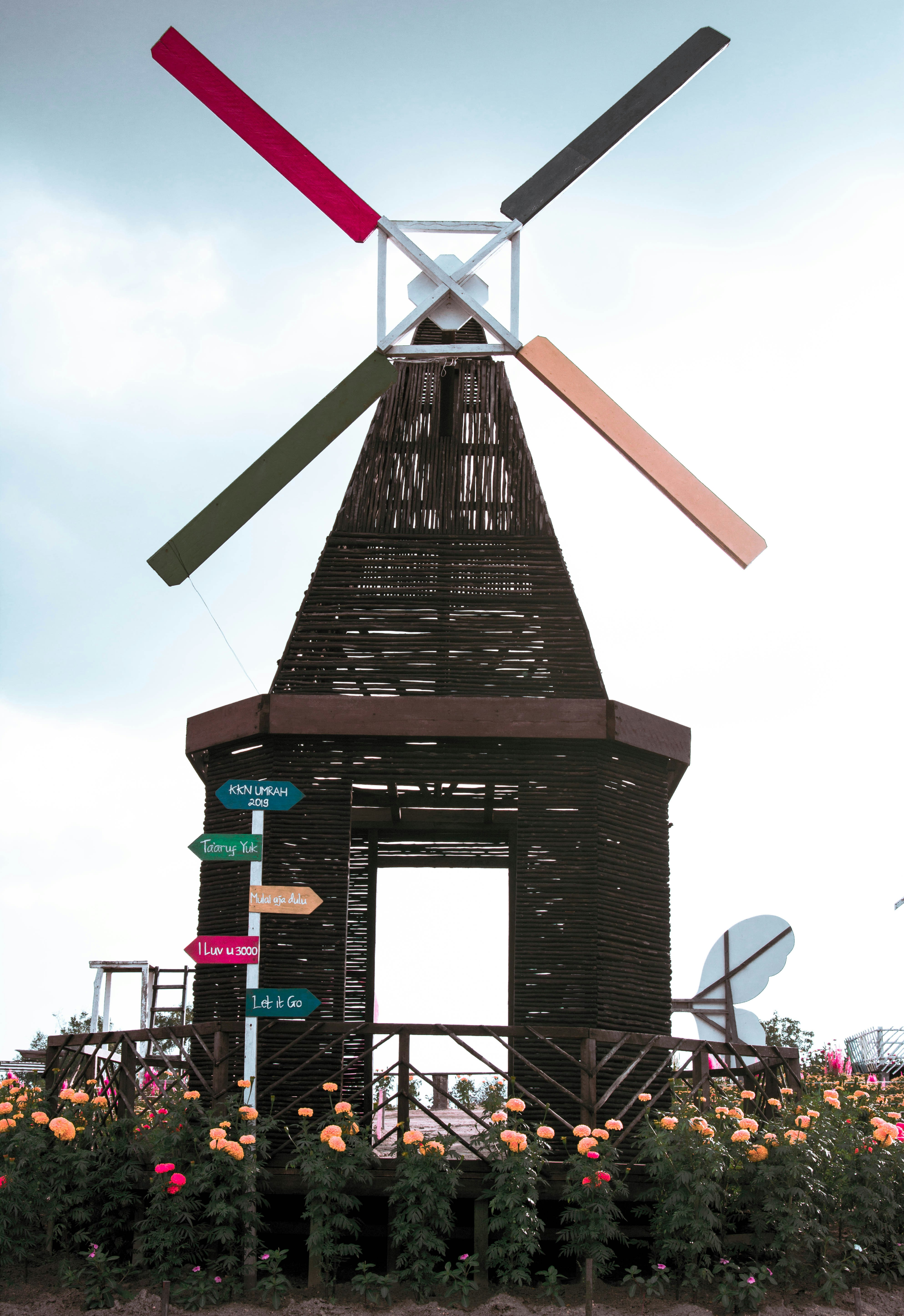 Painted Pinwheel Windmill: Rustic Tower Surrounded by Roses