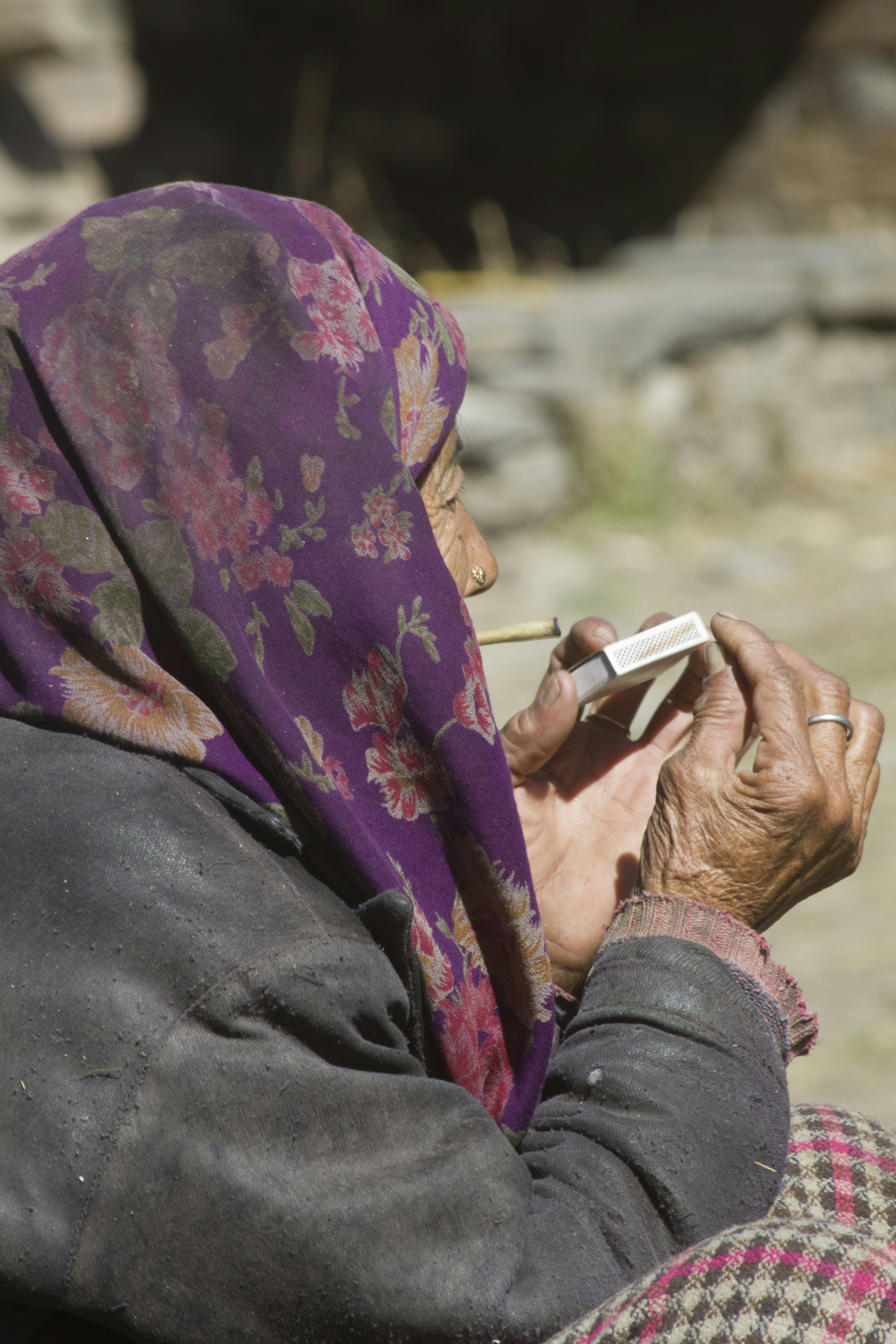 Close-up of a Weathered Hand Lightly Handling a Cigarette Pack