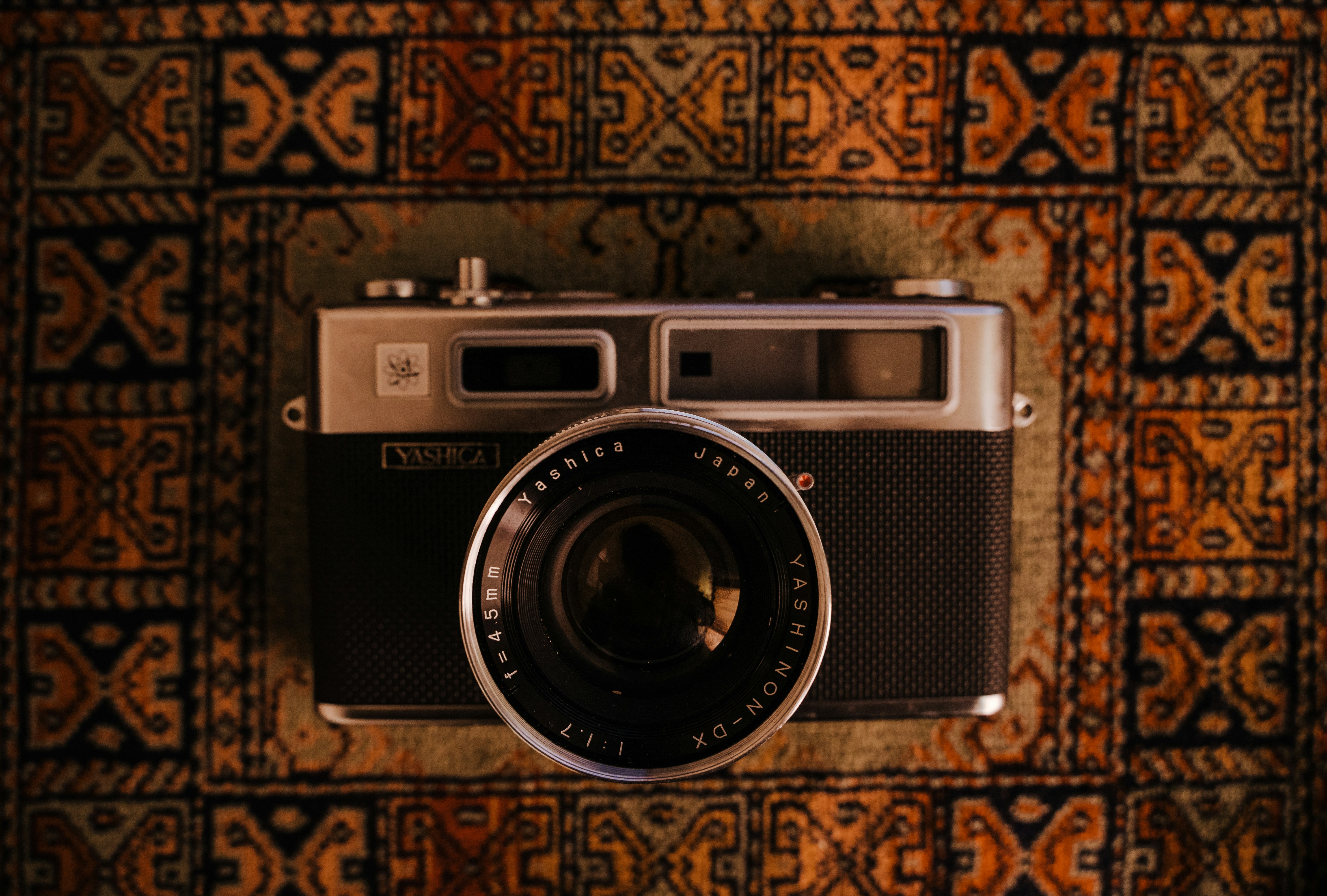 Classic Yashica camera positioned on a richly patterned textile, showcasing its vintage design and craftsmanship.