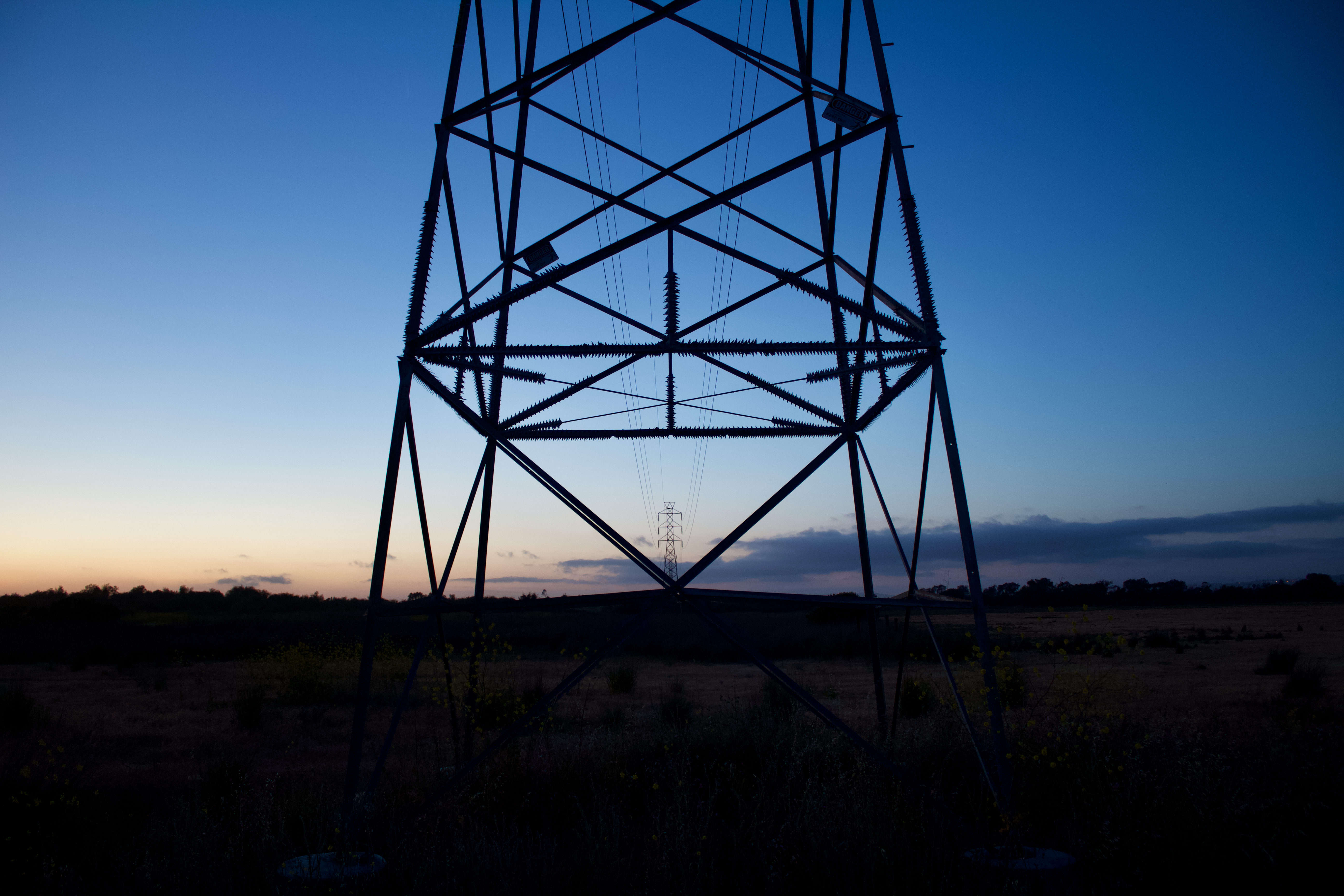 Silhouette of a metal tower against a twilight sky with soft gradient hues.