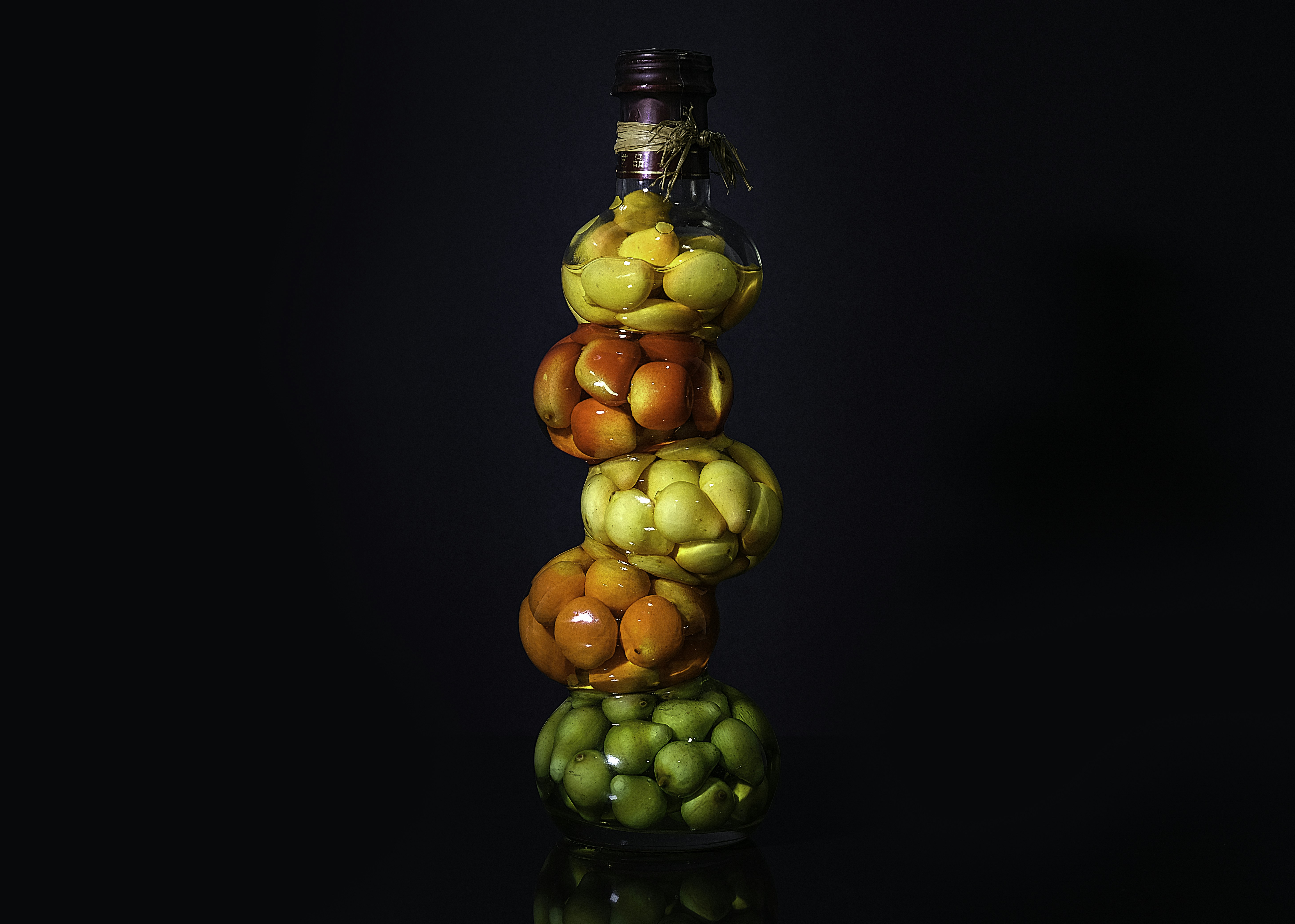 Citrus Cascade: Lemons, Oranges, and Limes Stacked in a Glass Bottle