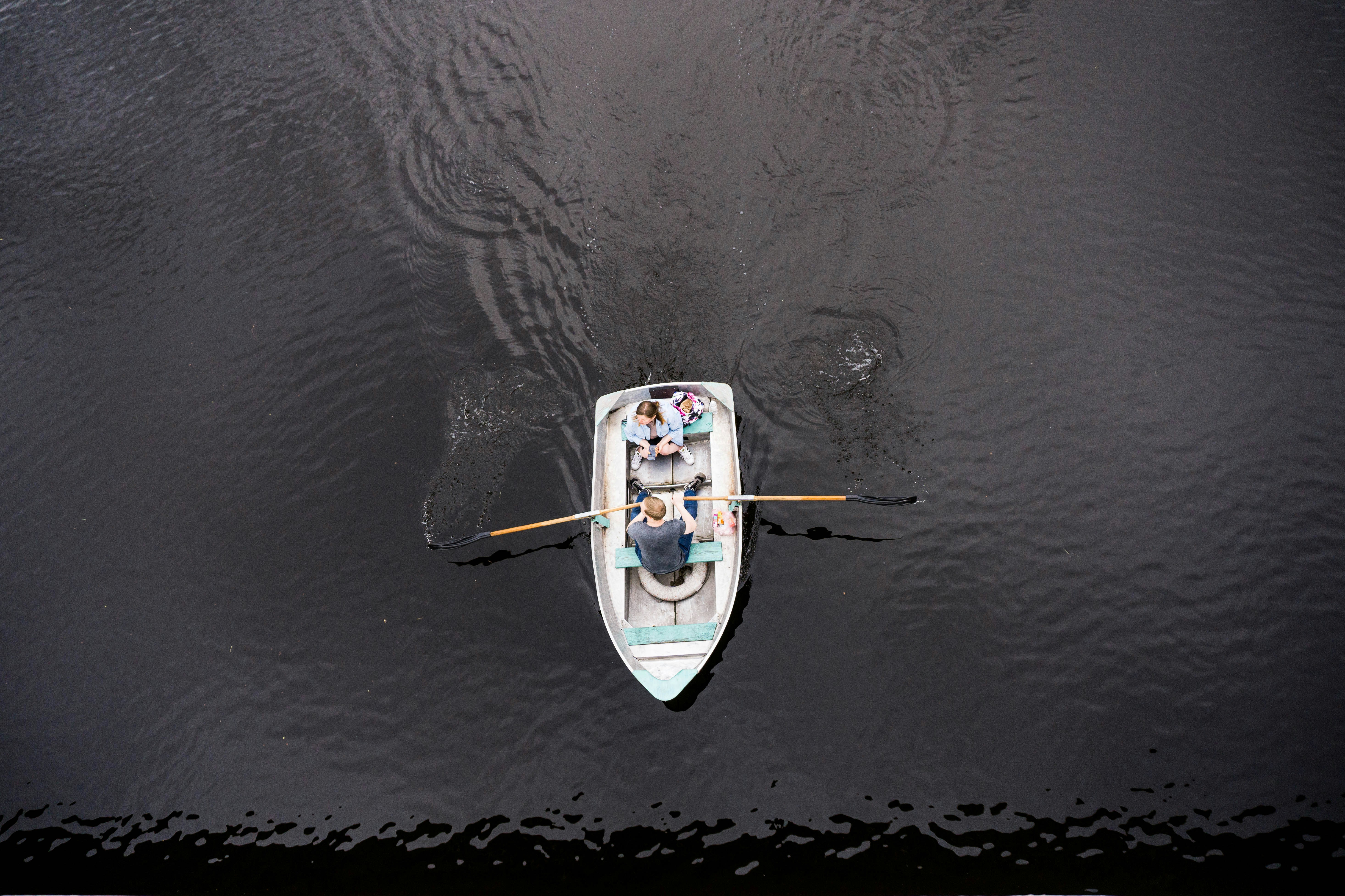 Couple in love ride in a rowing boat on the lake during sunset