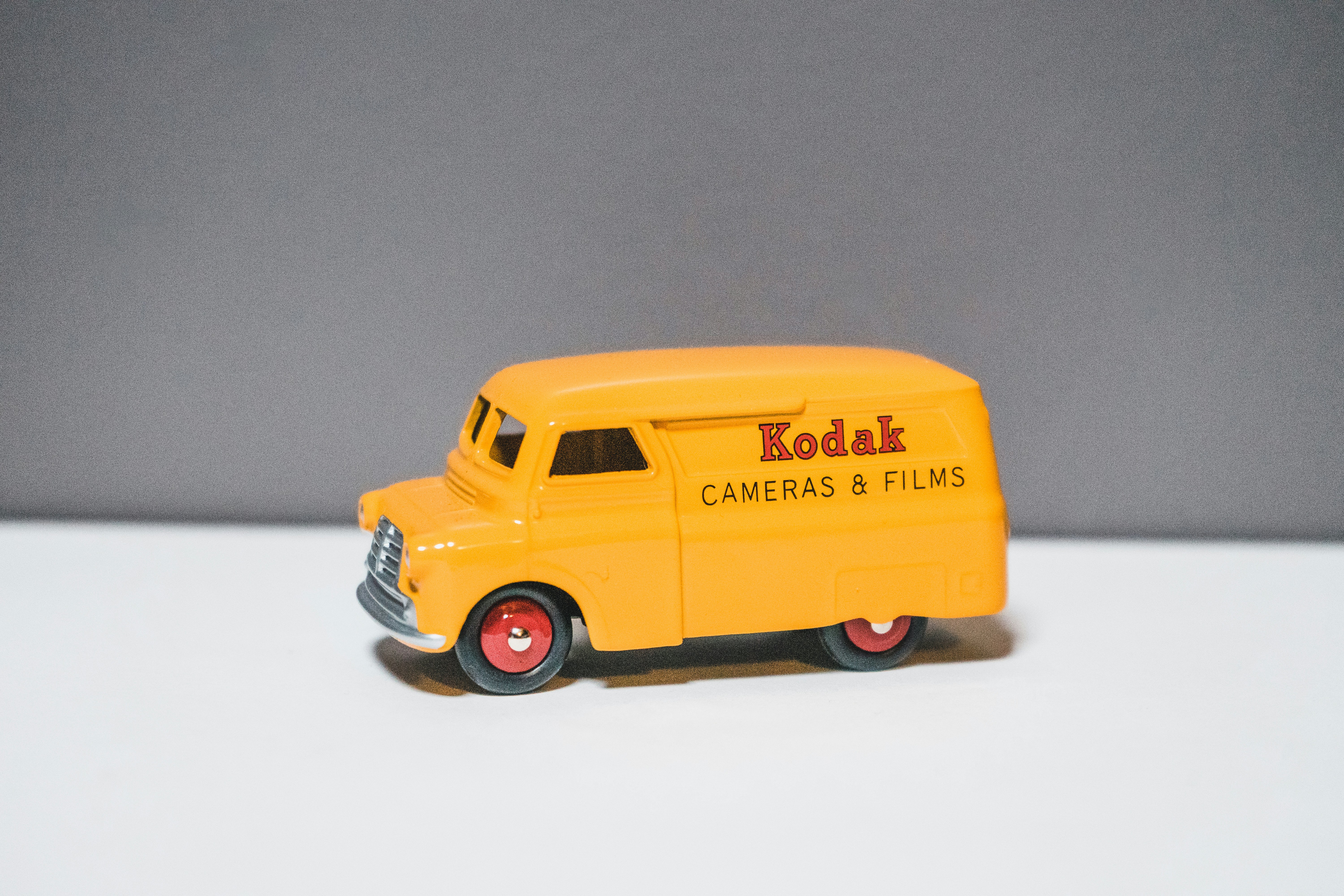 Bright yellow toy van with Kodak branding on a neutral background.
