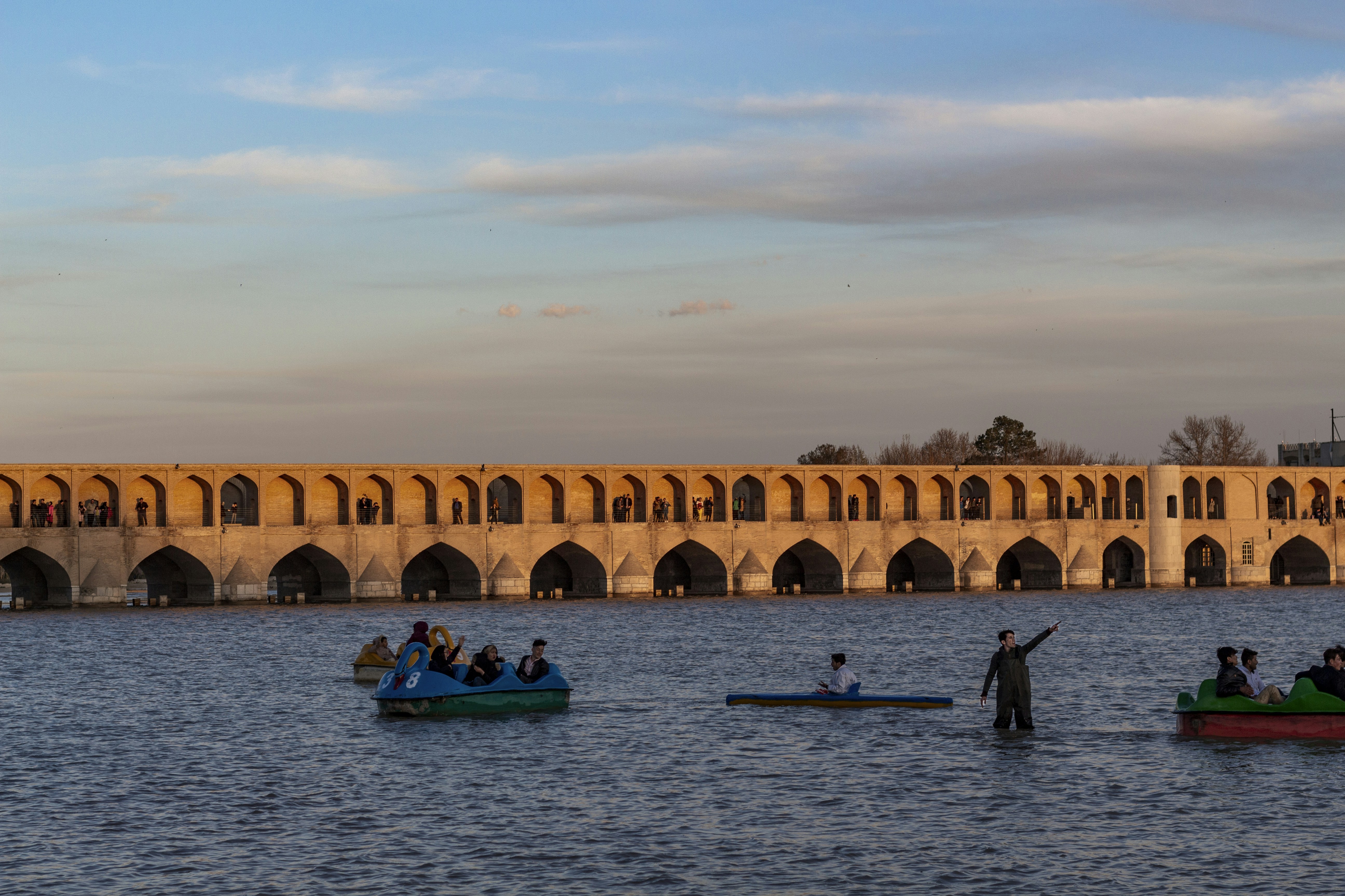 Sunlit Arches Over Calm Waters: A Riverside Scene