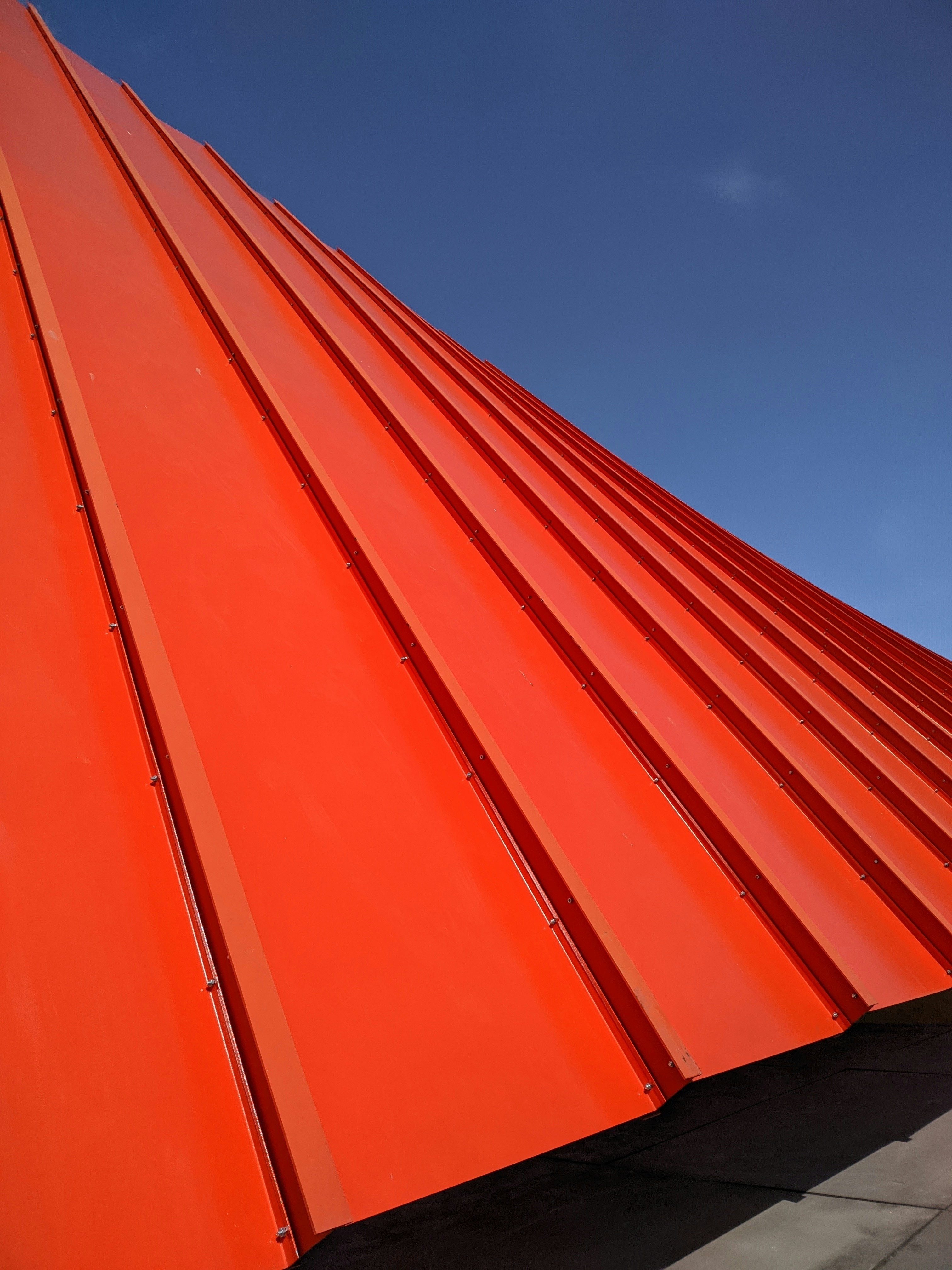 Crimson Ridge: Diagonal Metal Panels Under a Clear Blue Sky