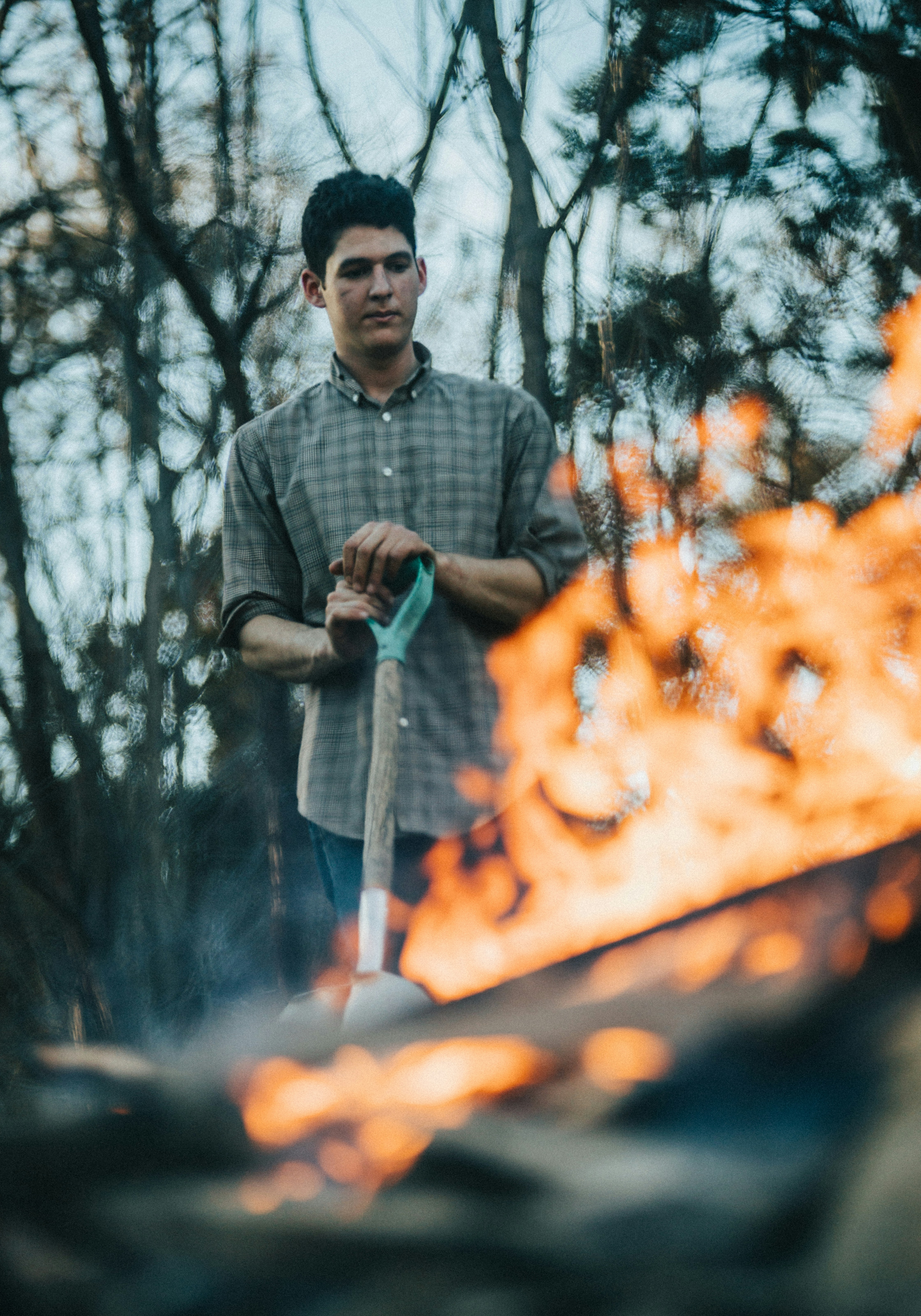 Tending the Ember: A Lone Figure Among Forest Flames