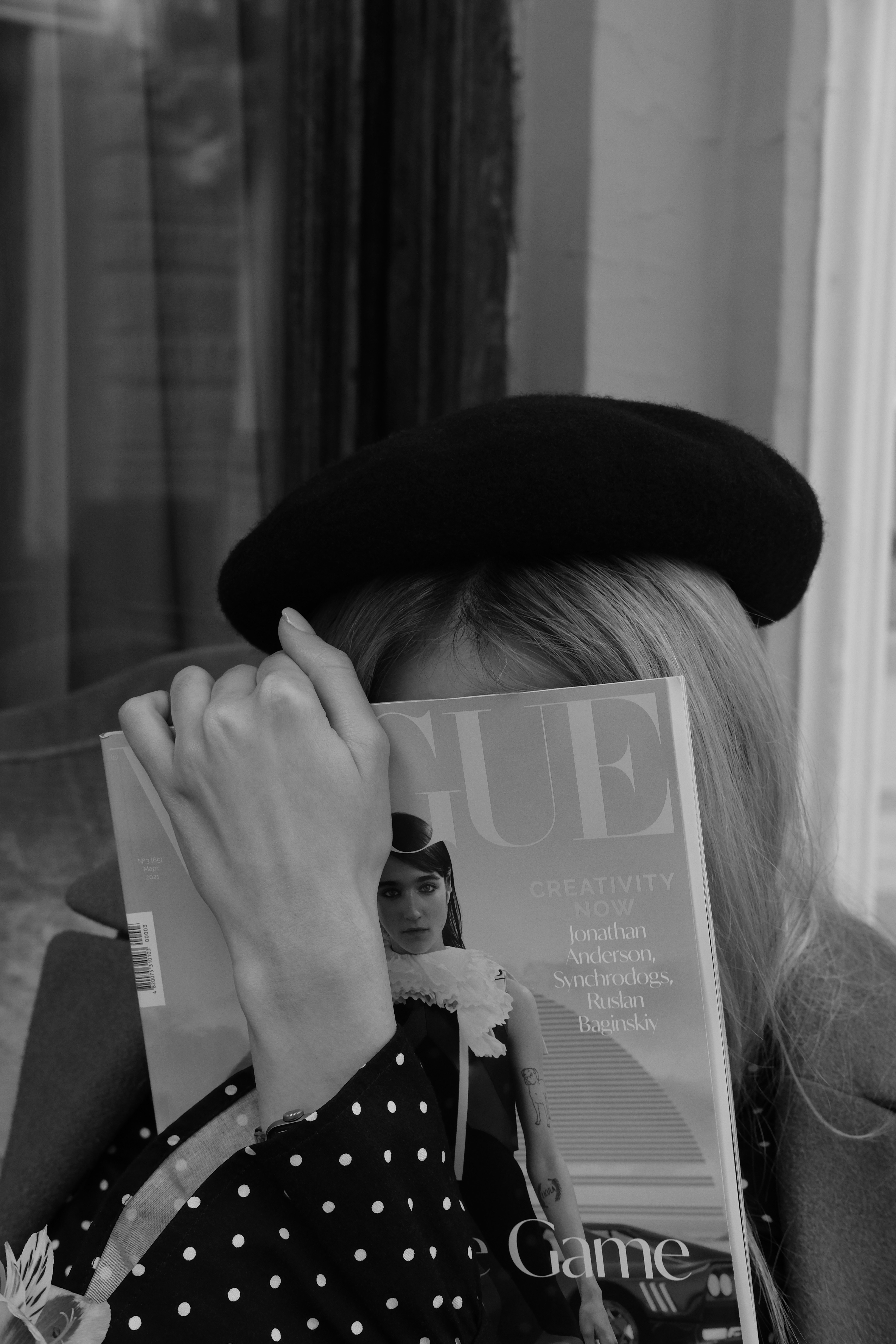 woman in black hat holding white printer paper