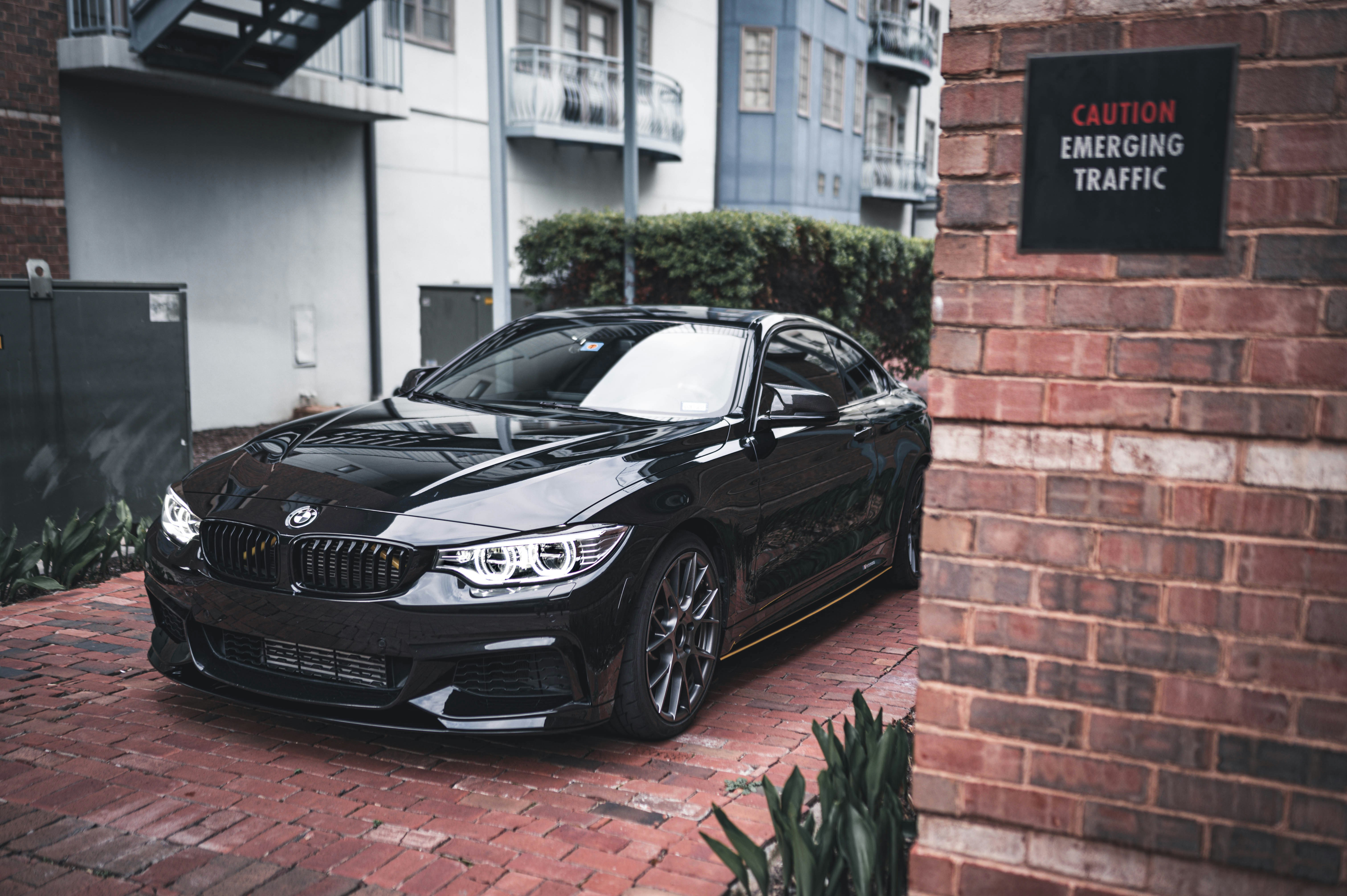 Midnight Precision: A BMW Stands Guard by Brick and Curb