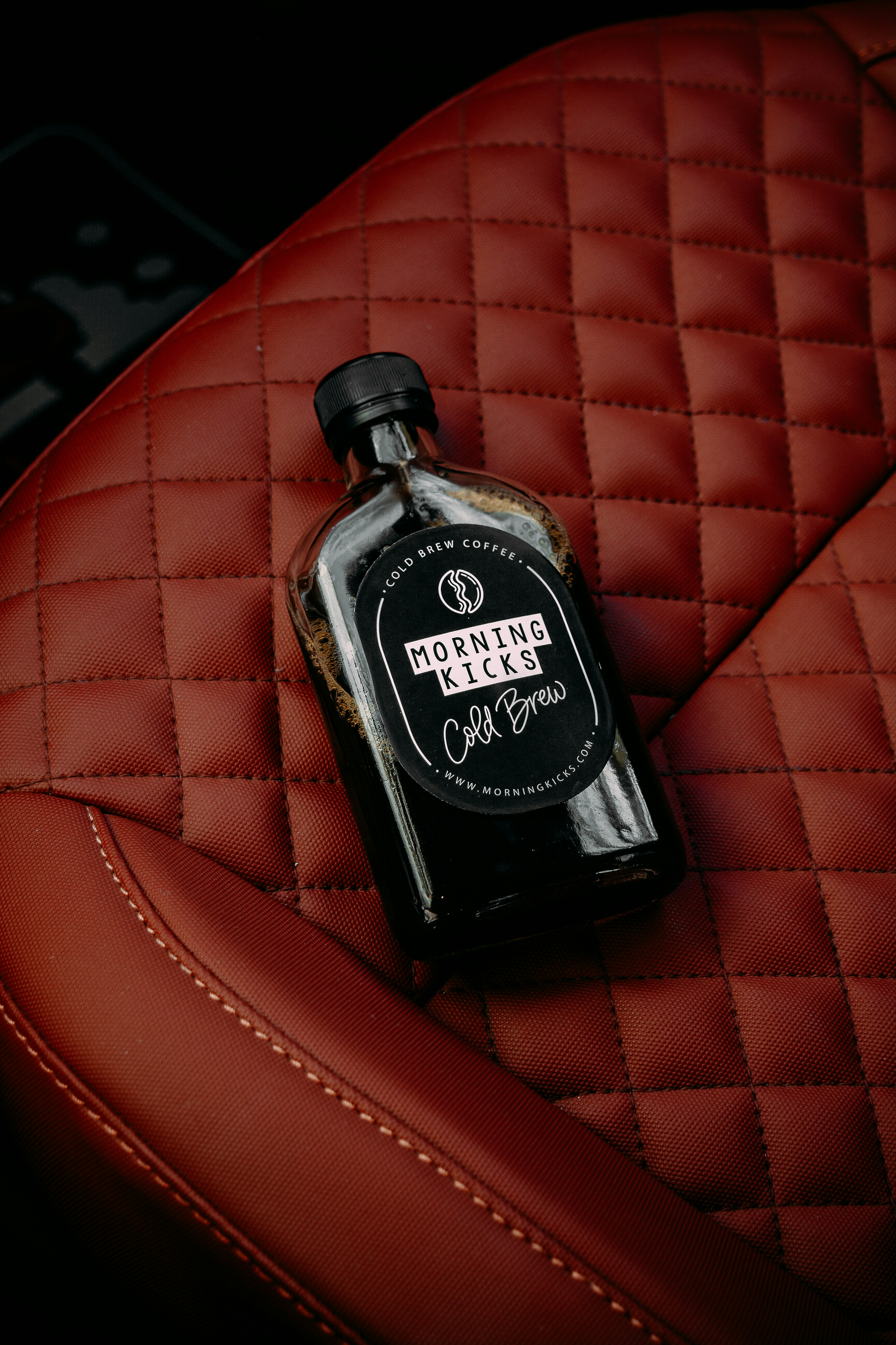 black and silver jack daniels bottle on red leather textile