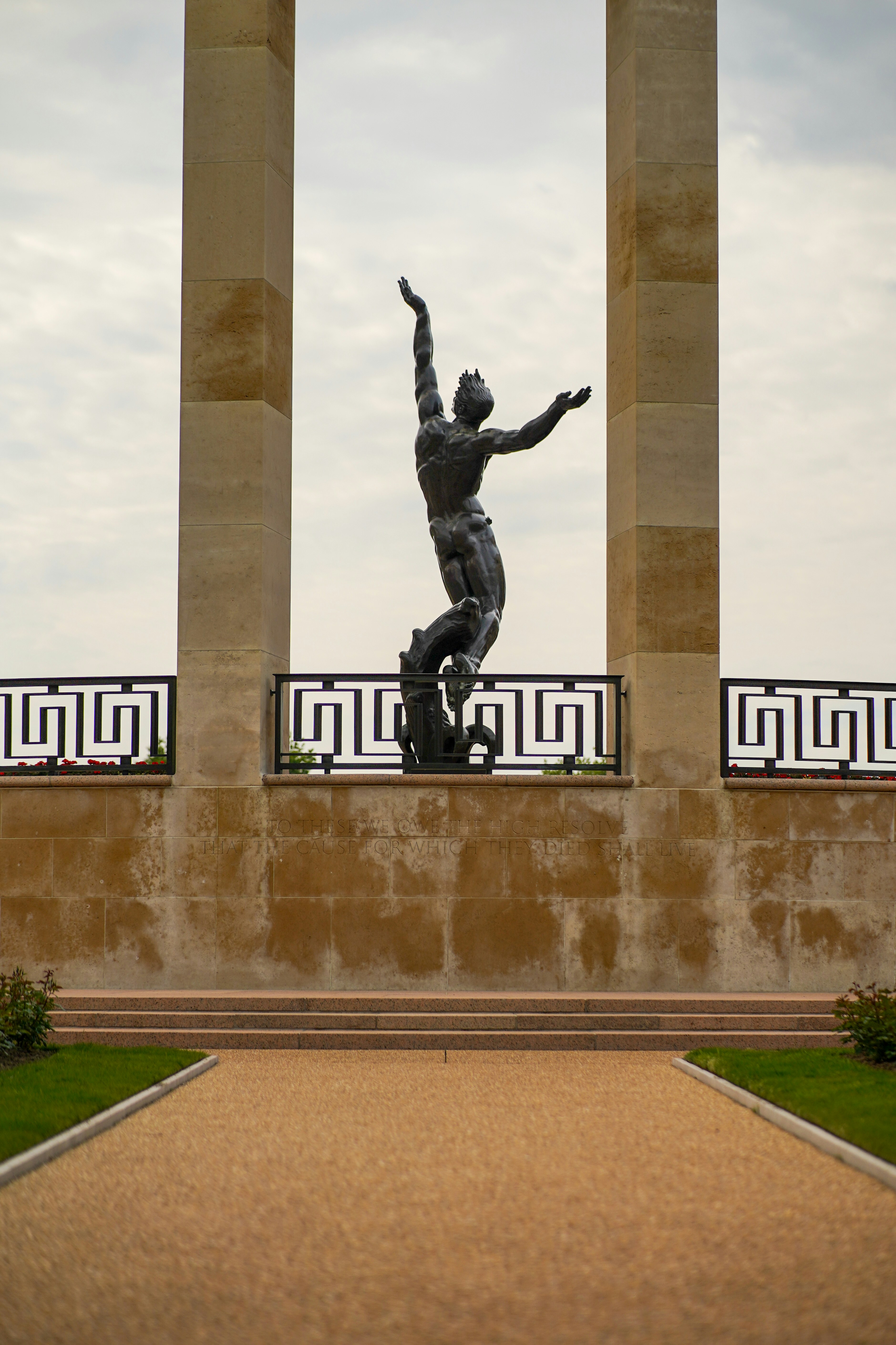 Between Pillars, a Bronze Figure Reaches Toward the Light