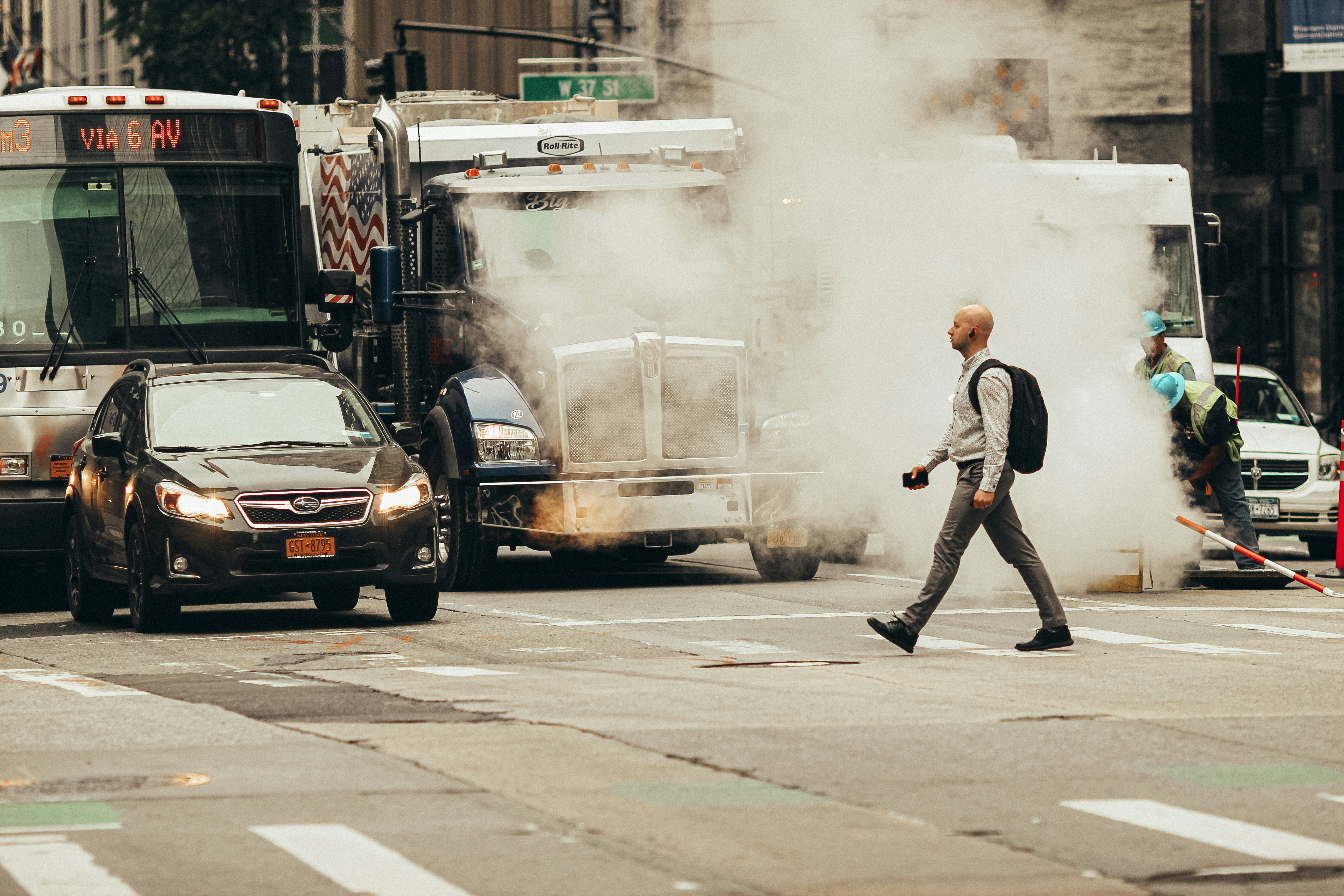 Steam Veil at the Crosswalk: A Pedestrian in Midtown Traffic