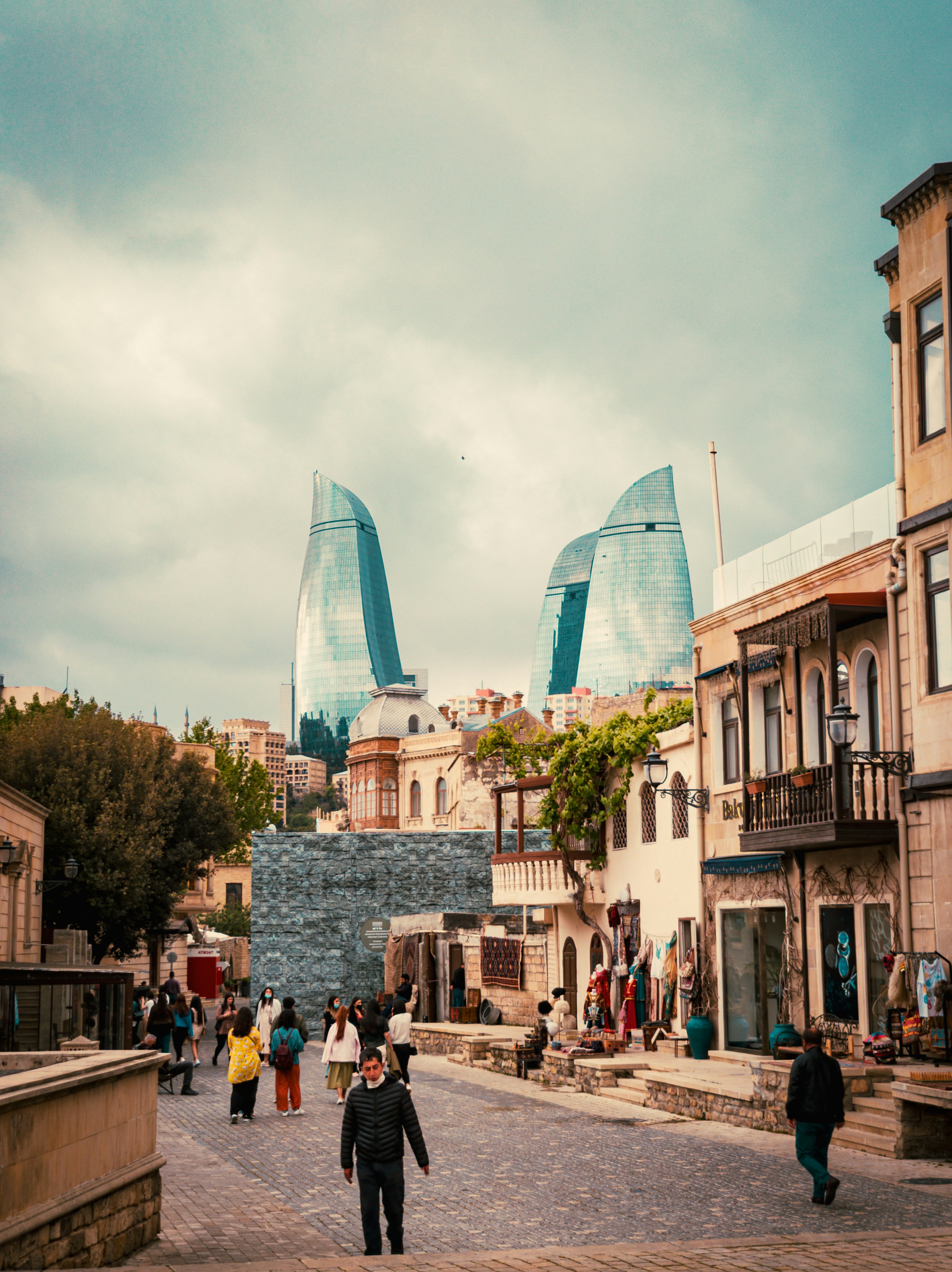 A vibrant street scene featuring traditional architecture alongside modern skyscrapers in the background. The blend of old and new captures the essence of urban evolution.