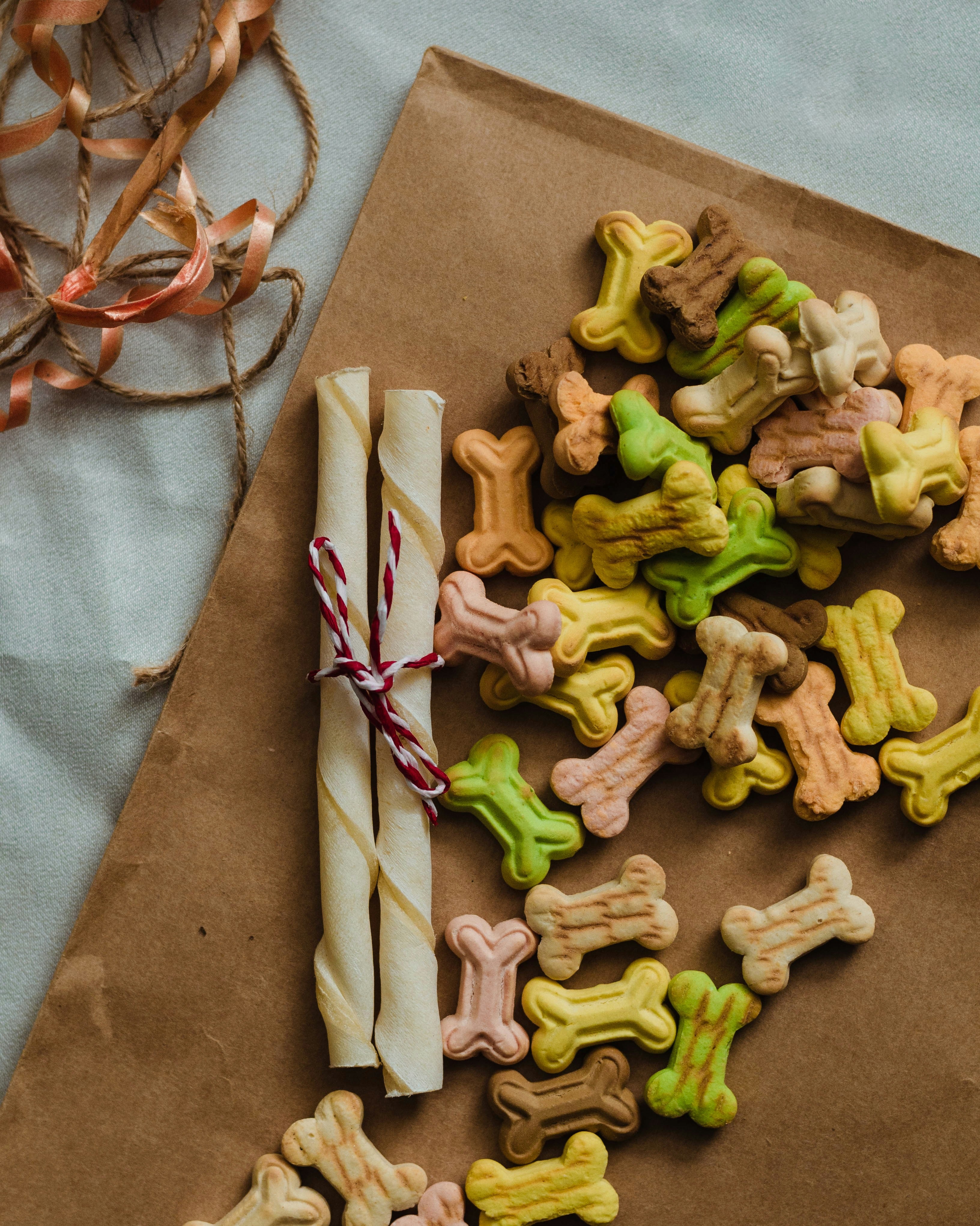 Pastel Bone Bonanza: a flat-lay of colorful dog treats on kraft