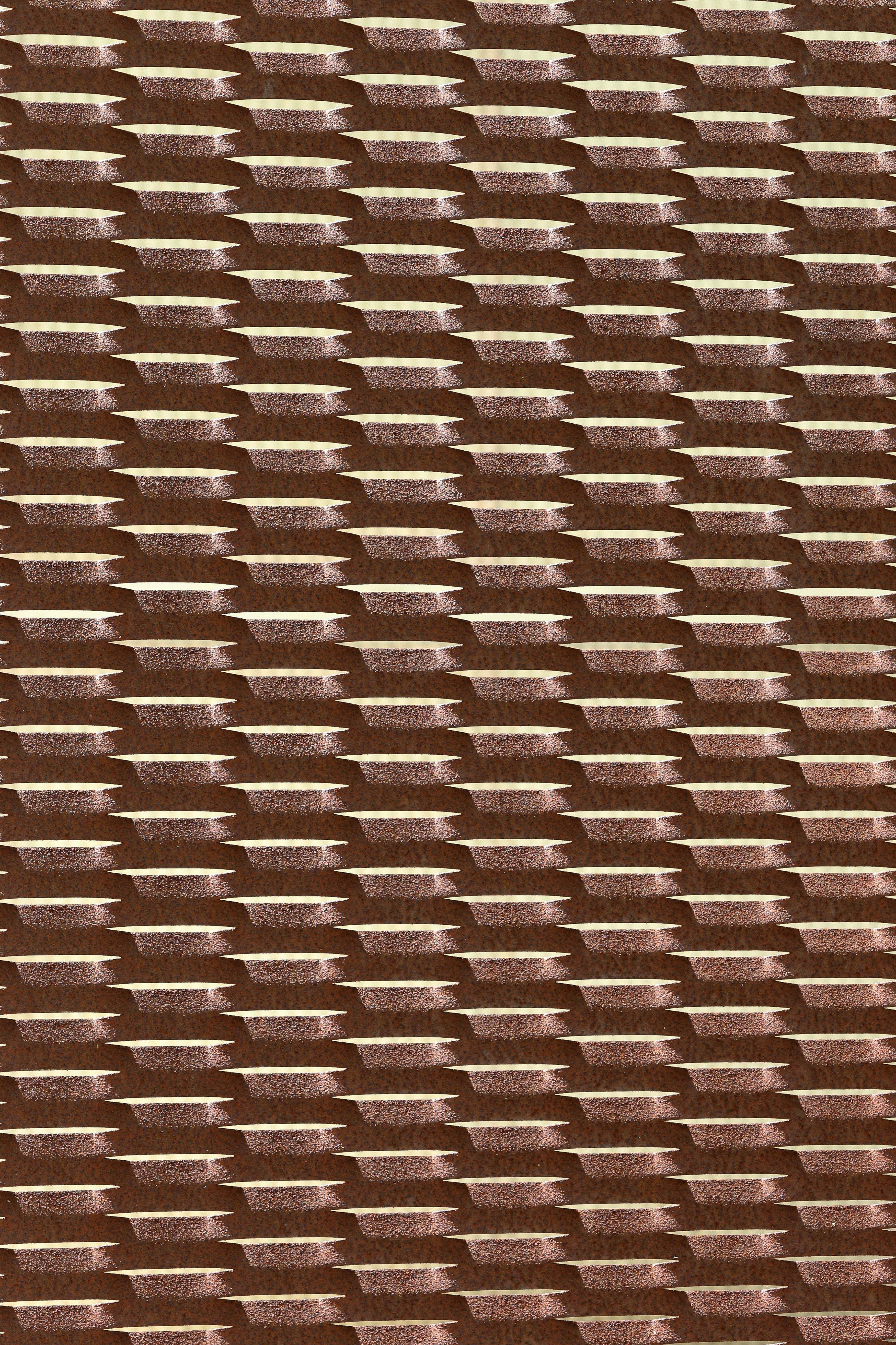 Close-up of a textured surface featuring a repetitive pattern of metallic elements, showcasing intricate design and craftsmanship.