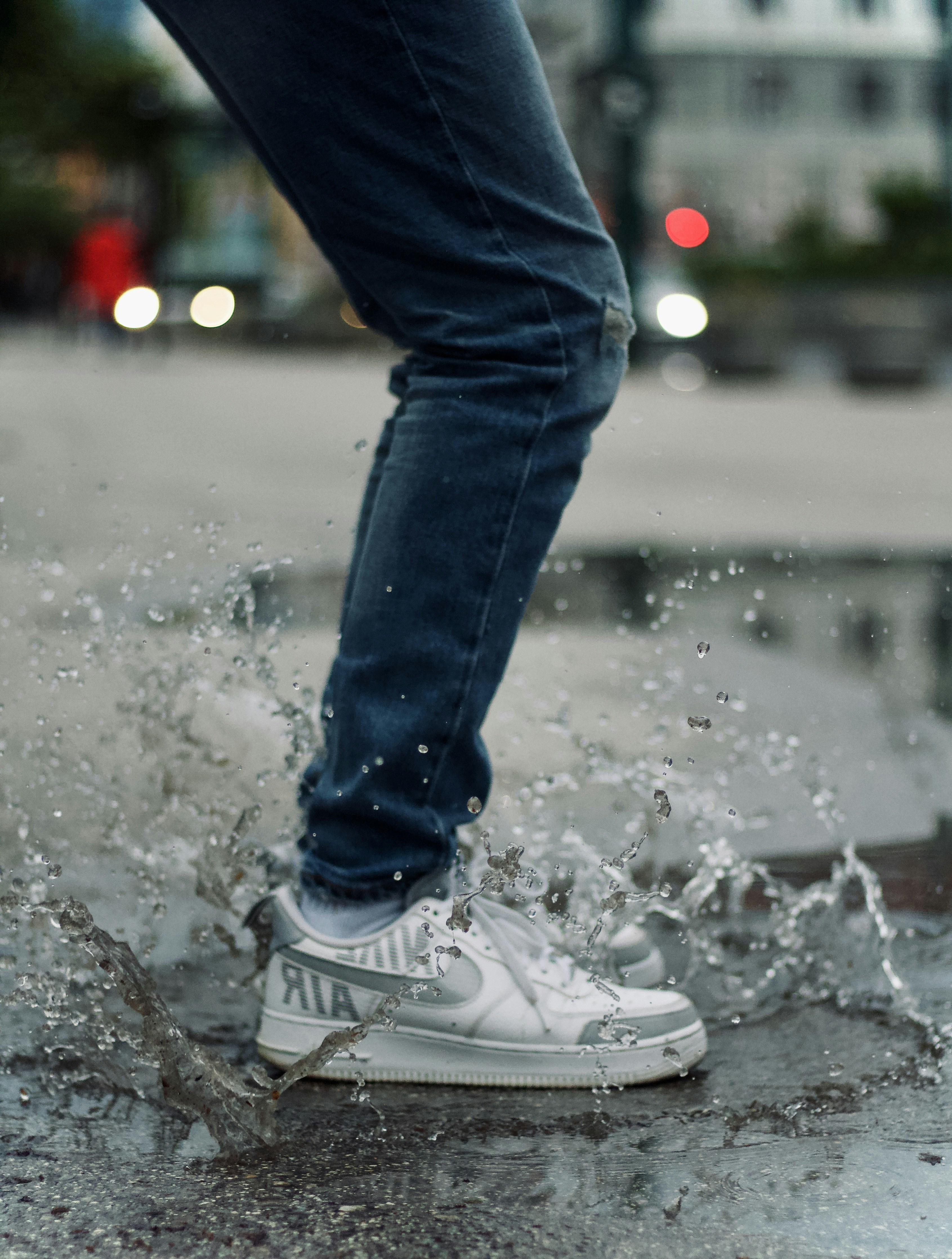 Puddle Jump in the City: White Nike Air Force 1 Steps Through a Rainy Splash
