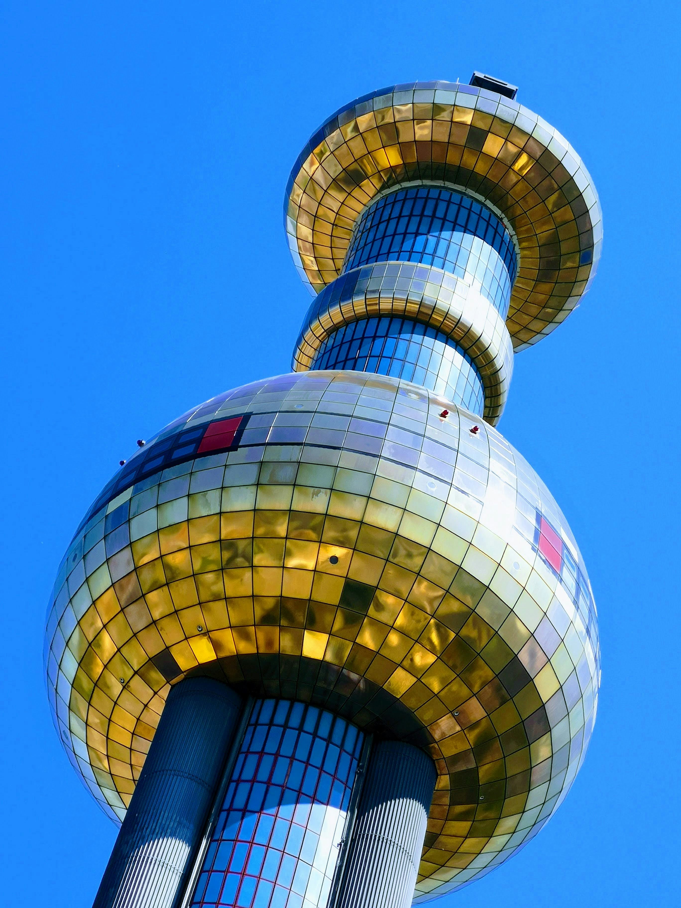 Gilded Spheres Above the Blue: A Mosaic Tower Reaching the Sky