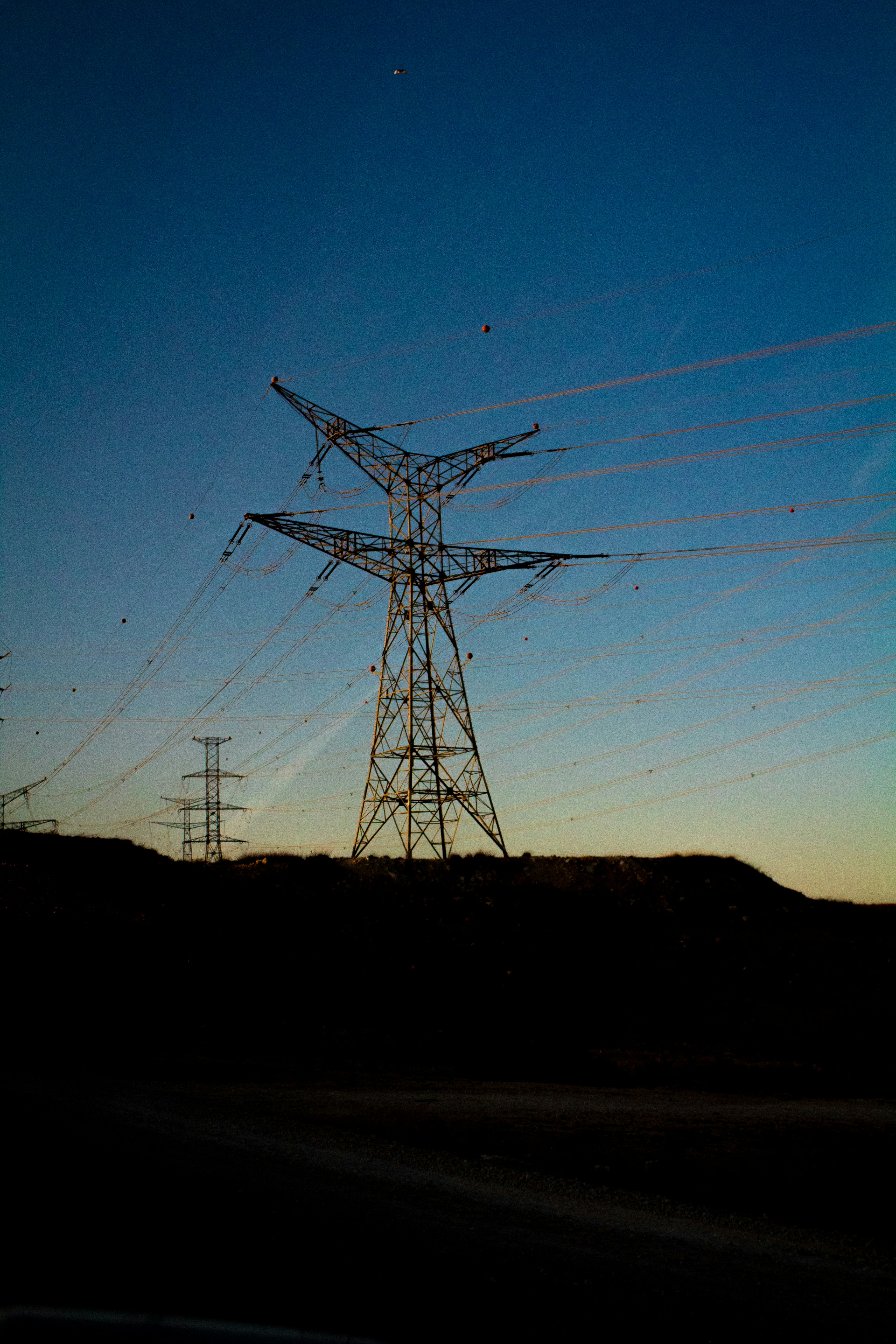 Gray electric towers on brown hill under blue sky during daytime photo ...