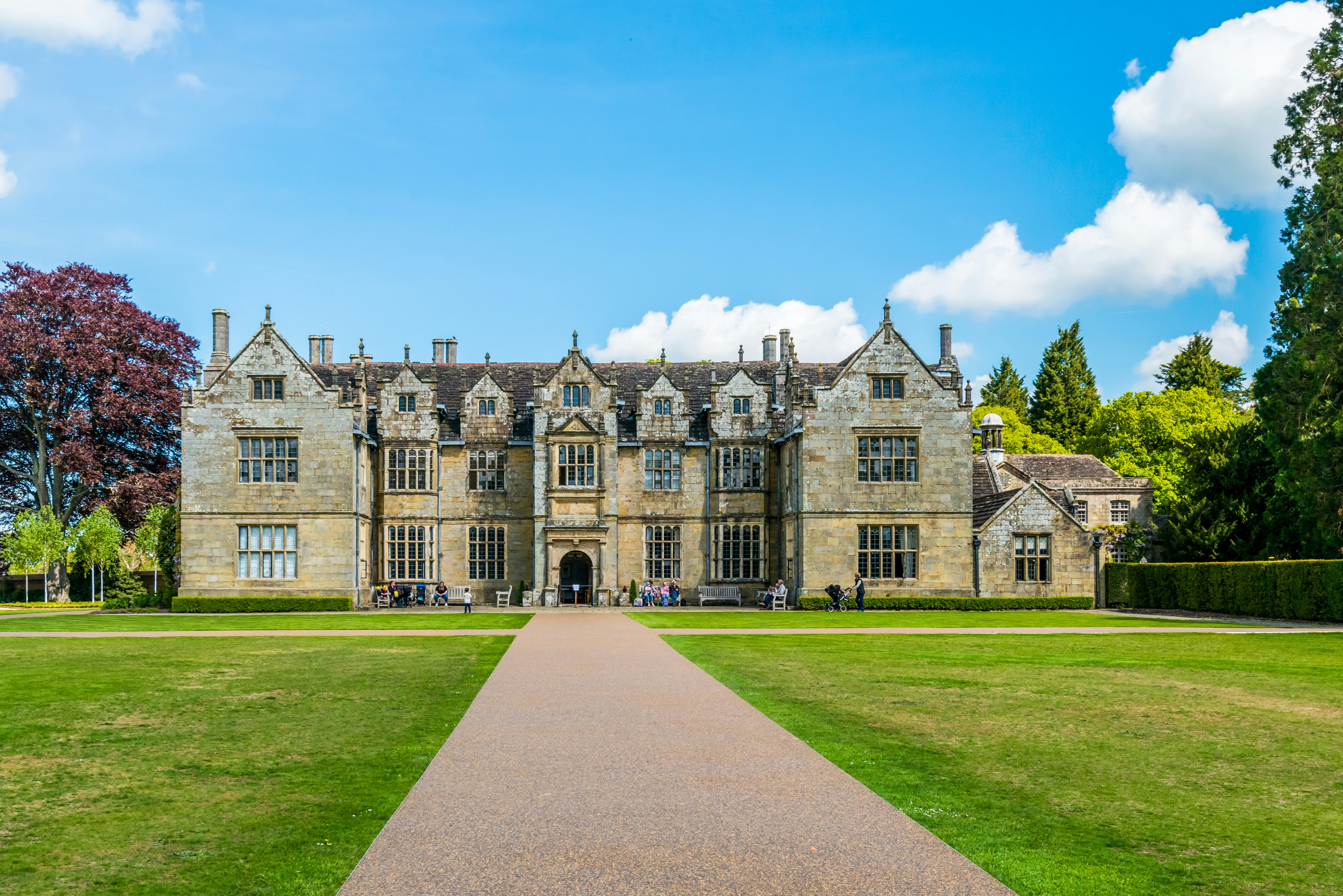 Historic stone manor with intricate architecture set against a vibrant blue sky.