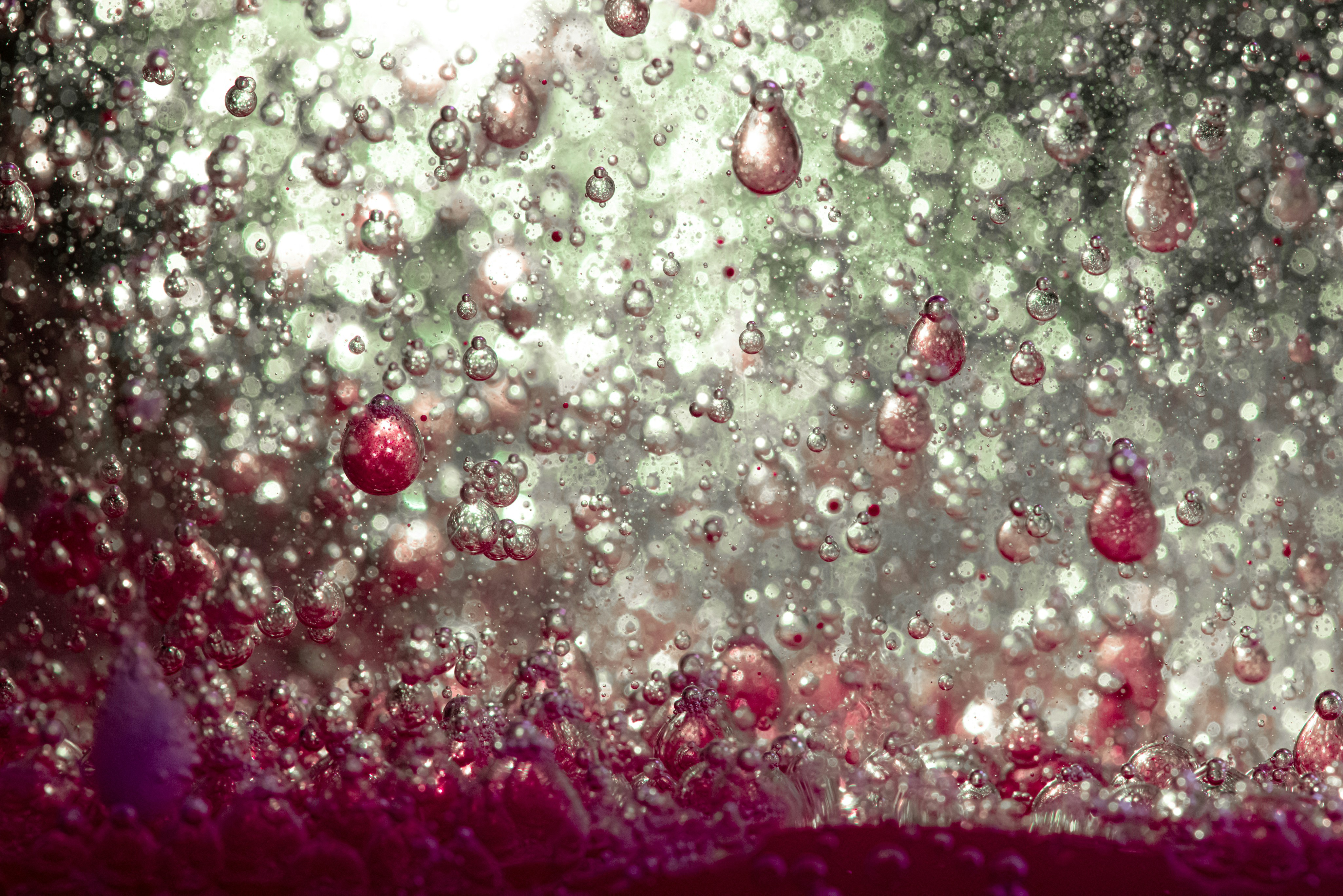 Crimson Orbs in a Green Glimmer: A Macro Bubble Portrait